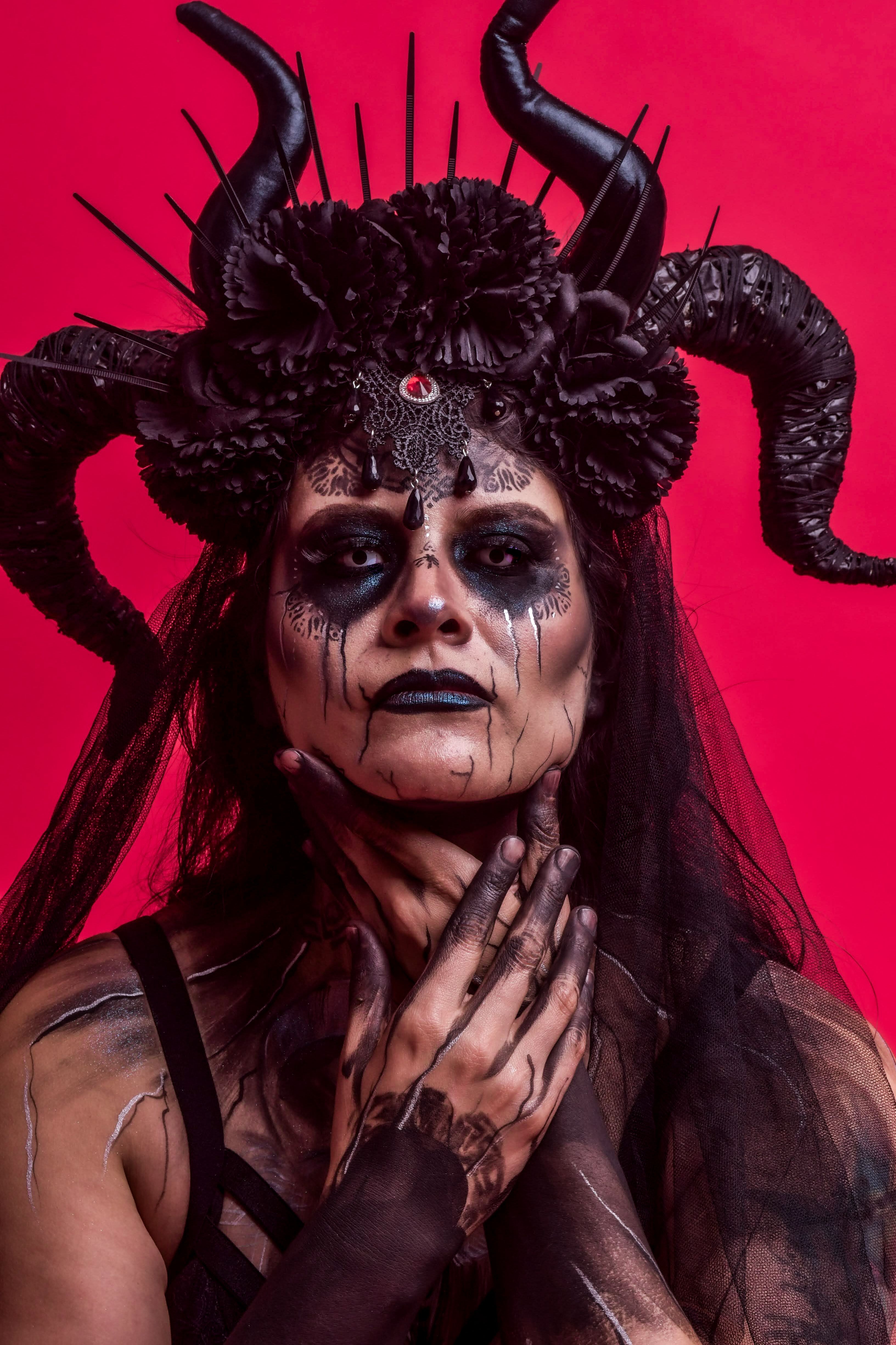 Striking Gothic Costume Portrait Against Red · Free Stock Photo