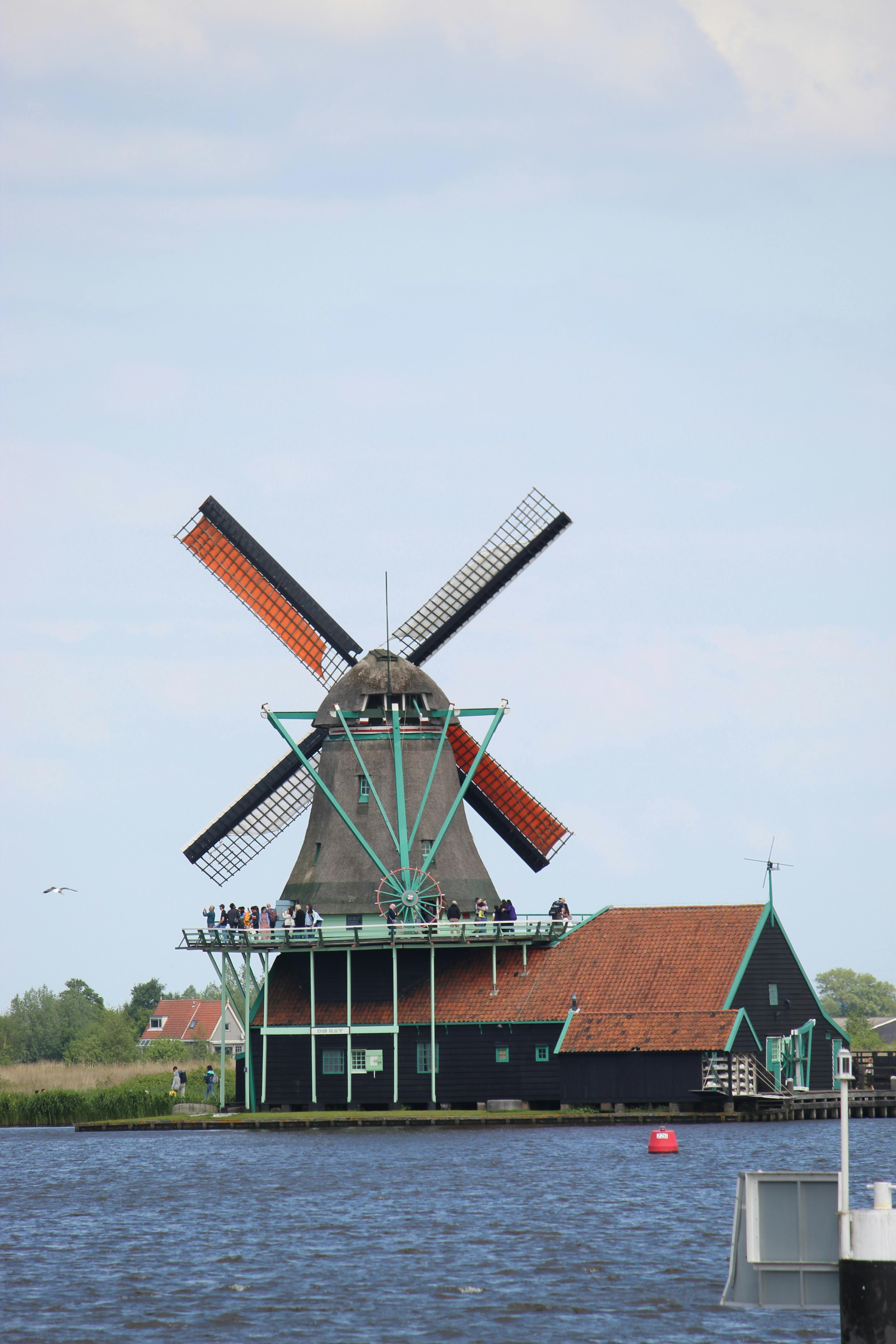 Traditional Dutch Windmill by a Lake on a Clear Day · Free Stock Photo