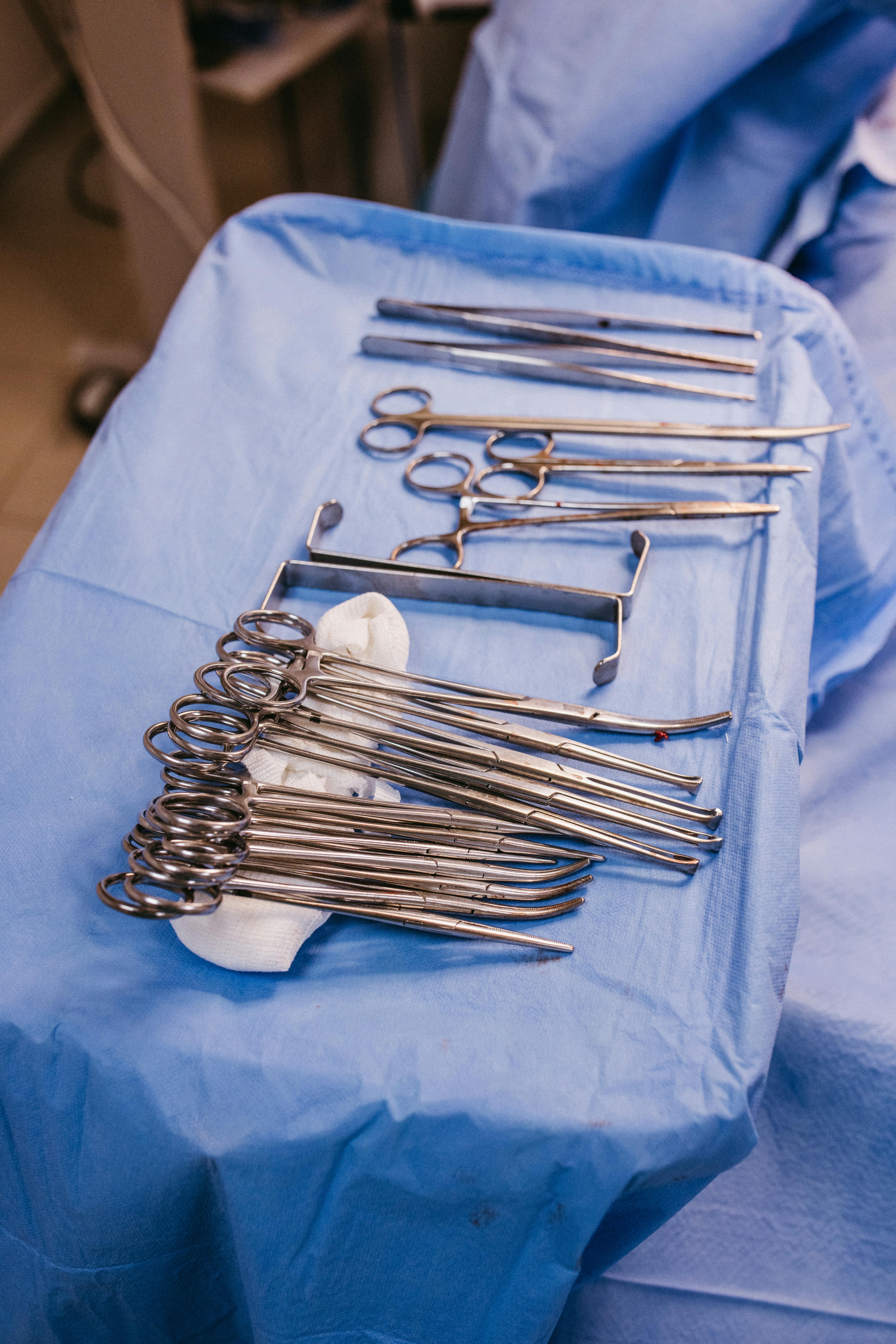 Array of Surgical Instruments on Blue Drape · Free Stock Photo