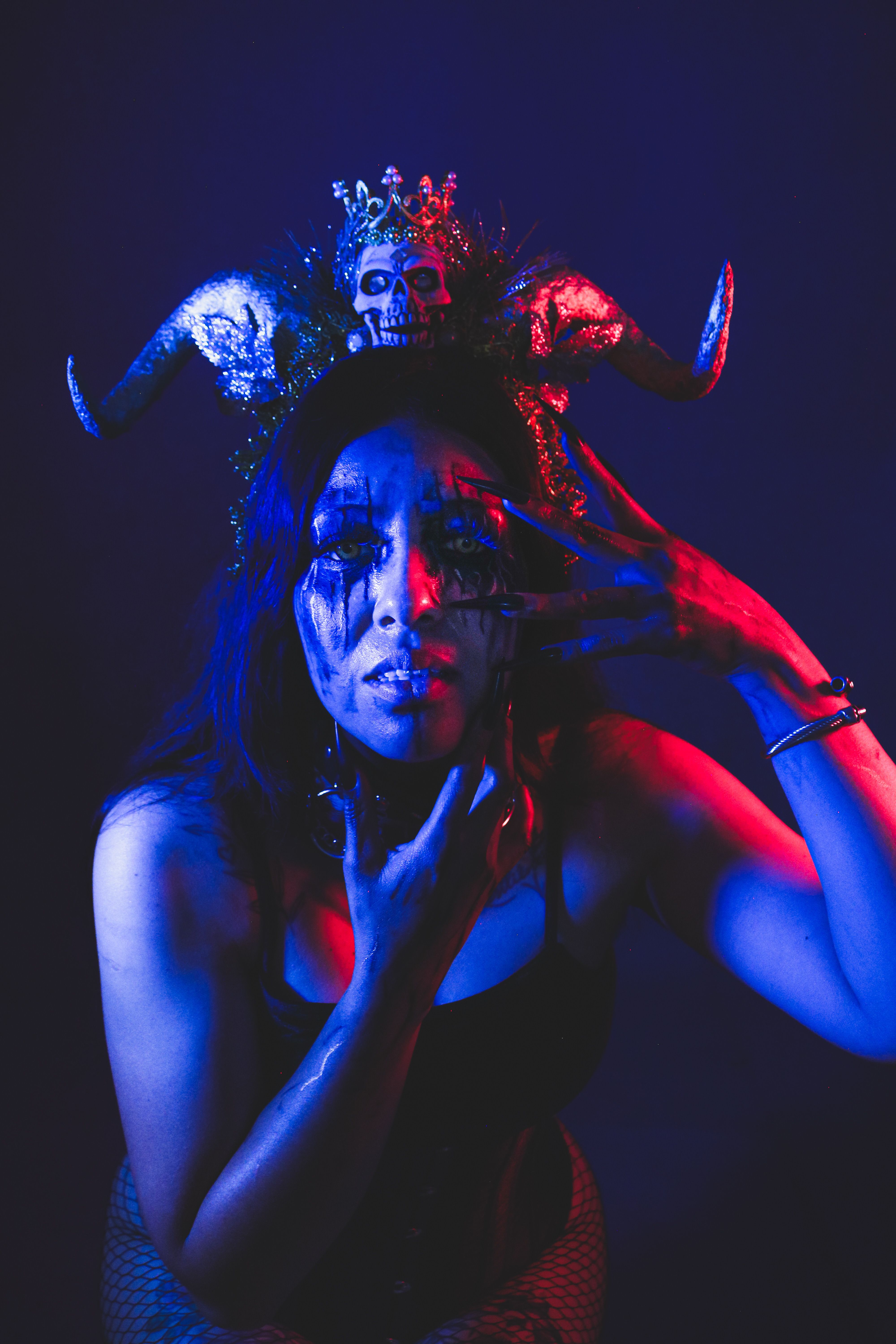Dramatic Portrait with Skull Headdress in Blue Red Light · Free Stock Photo