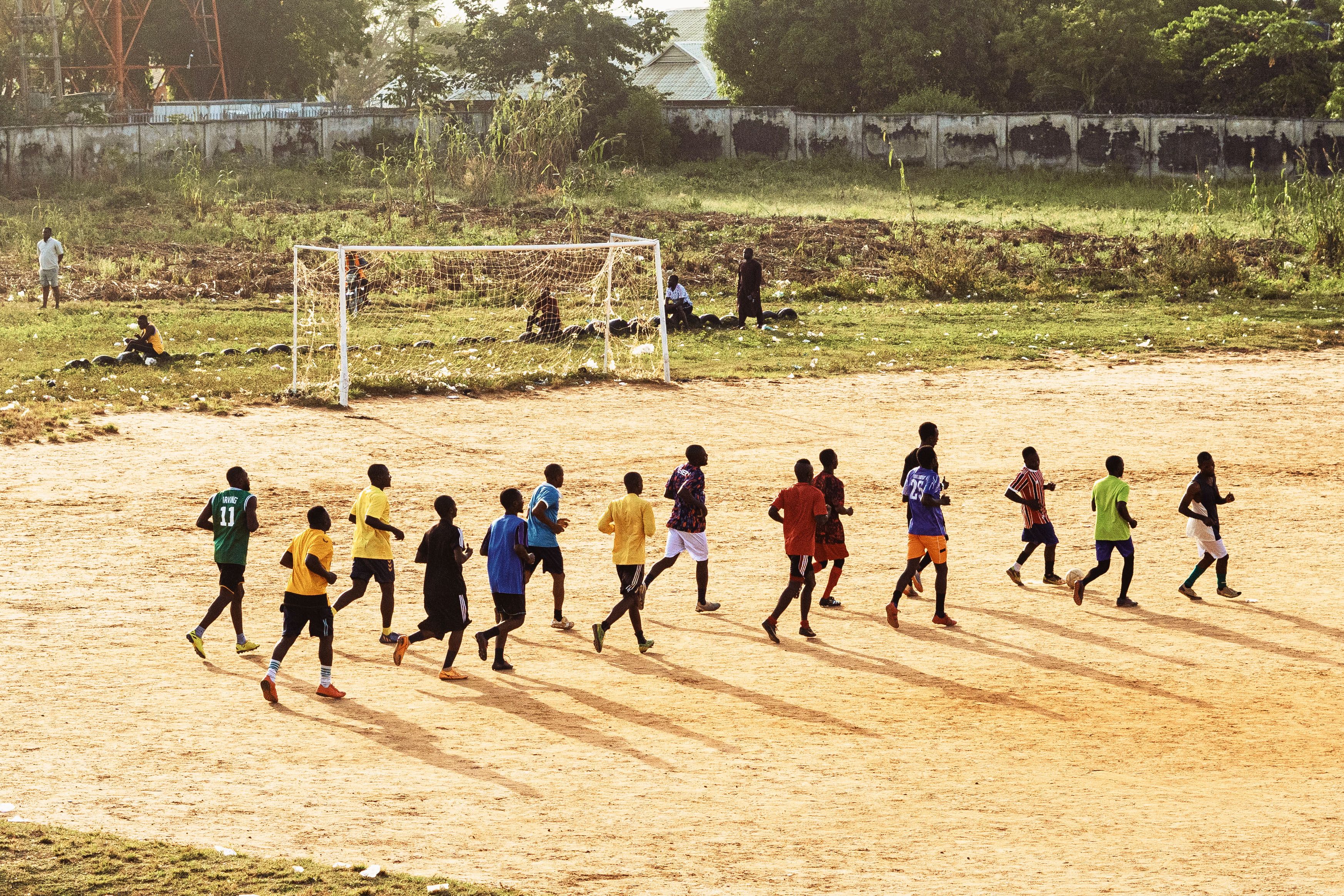 Youth Soccer Practice on Dirt Field in Sunlight · Free Stock Photo