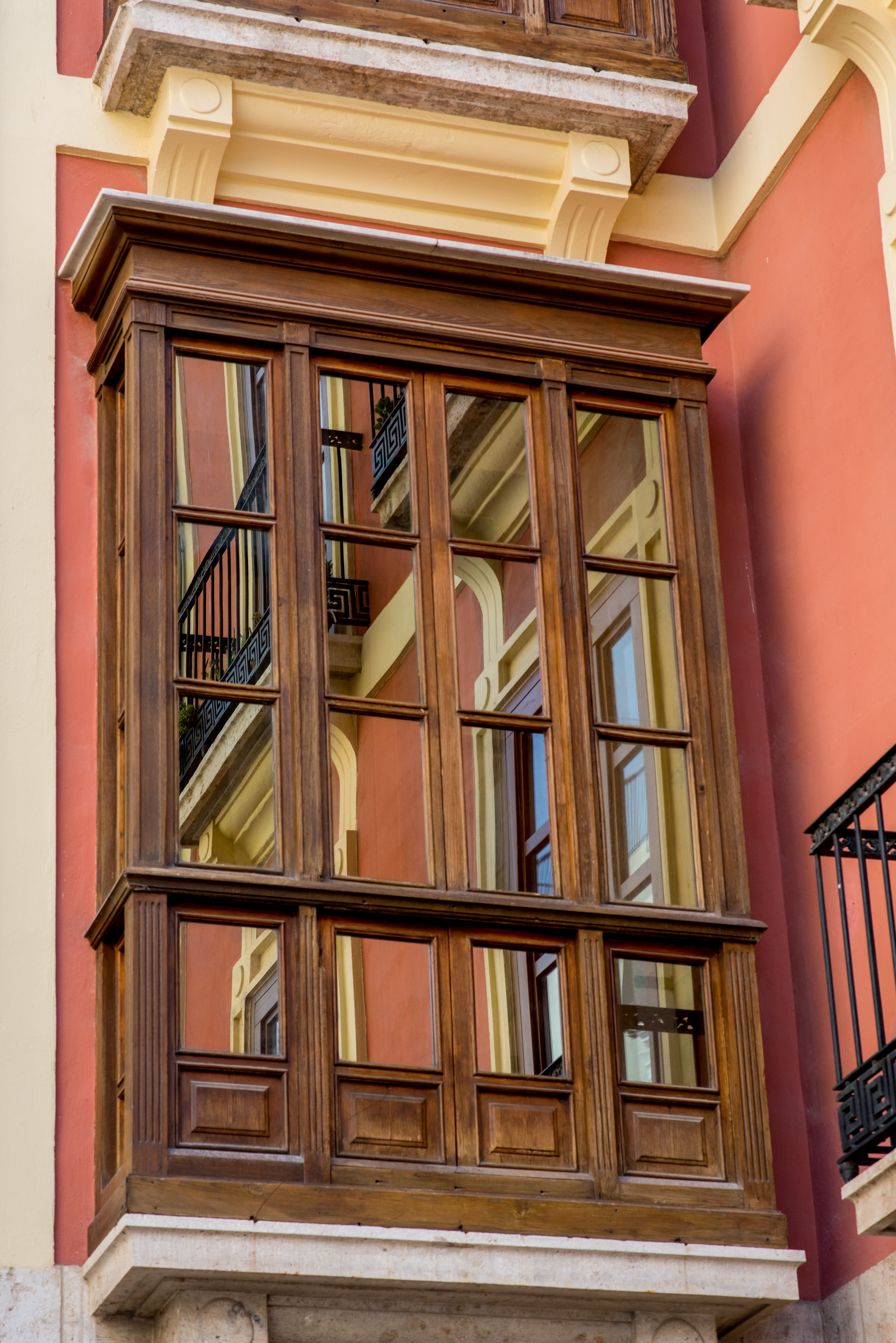 Elegant Wooden Balcony on Red Building Façade · Free Stock Photo