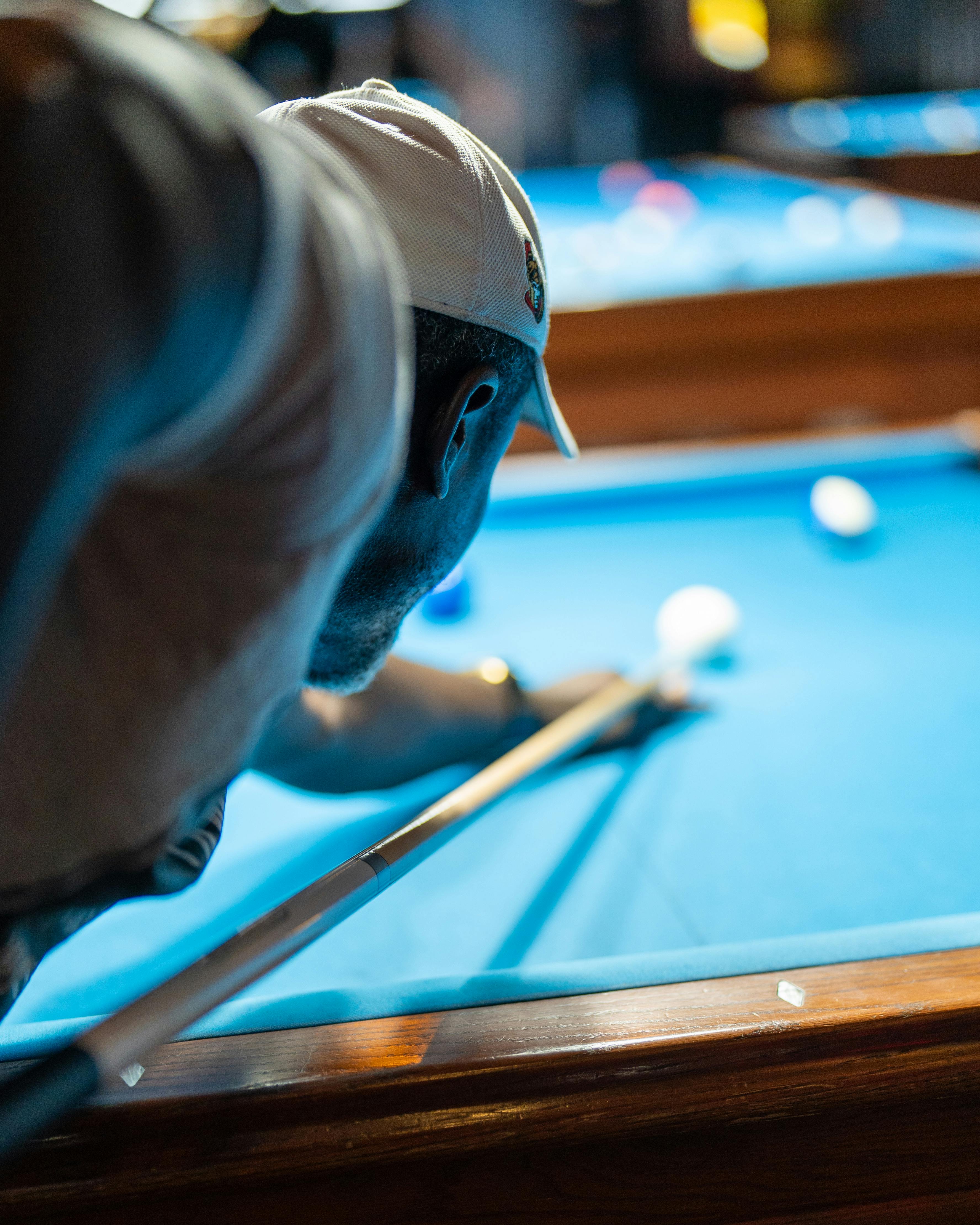 Man Playing Pool in a Dimly Lit Room · Free Stock Photo