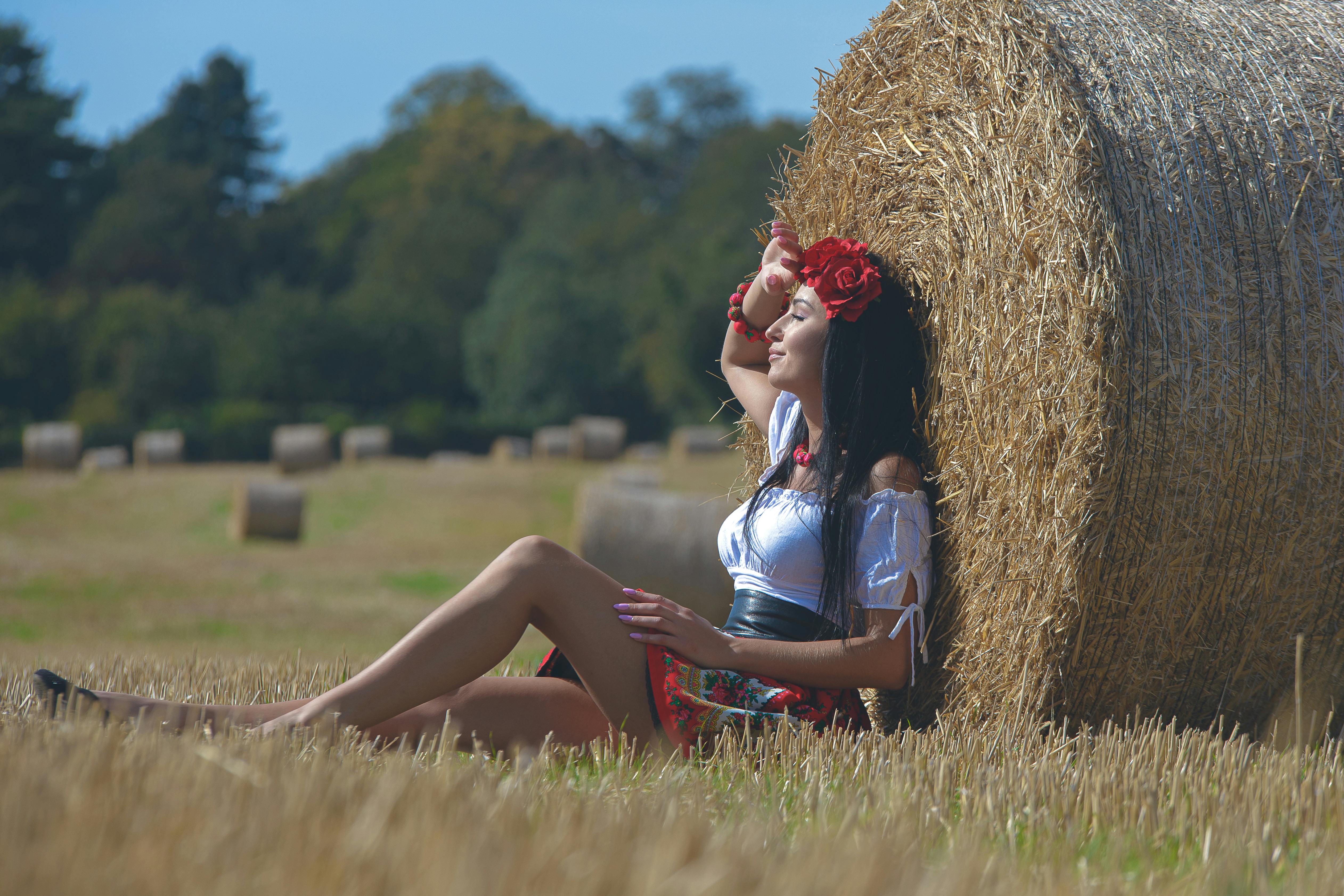 Woman Relaxing in Summer Field with Hay Bales · Free Stock Photo