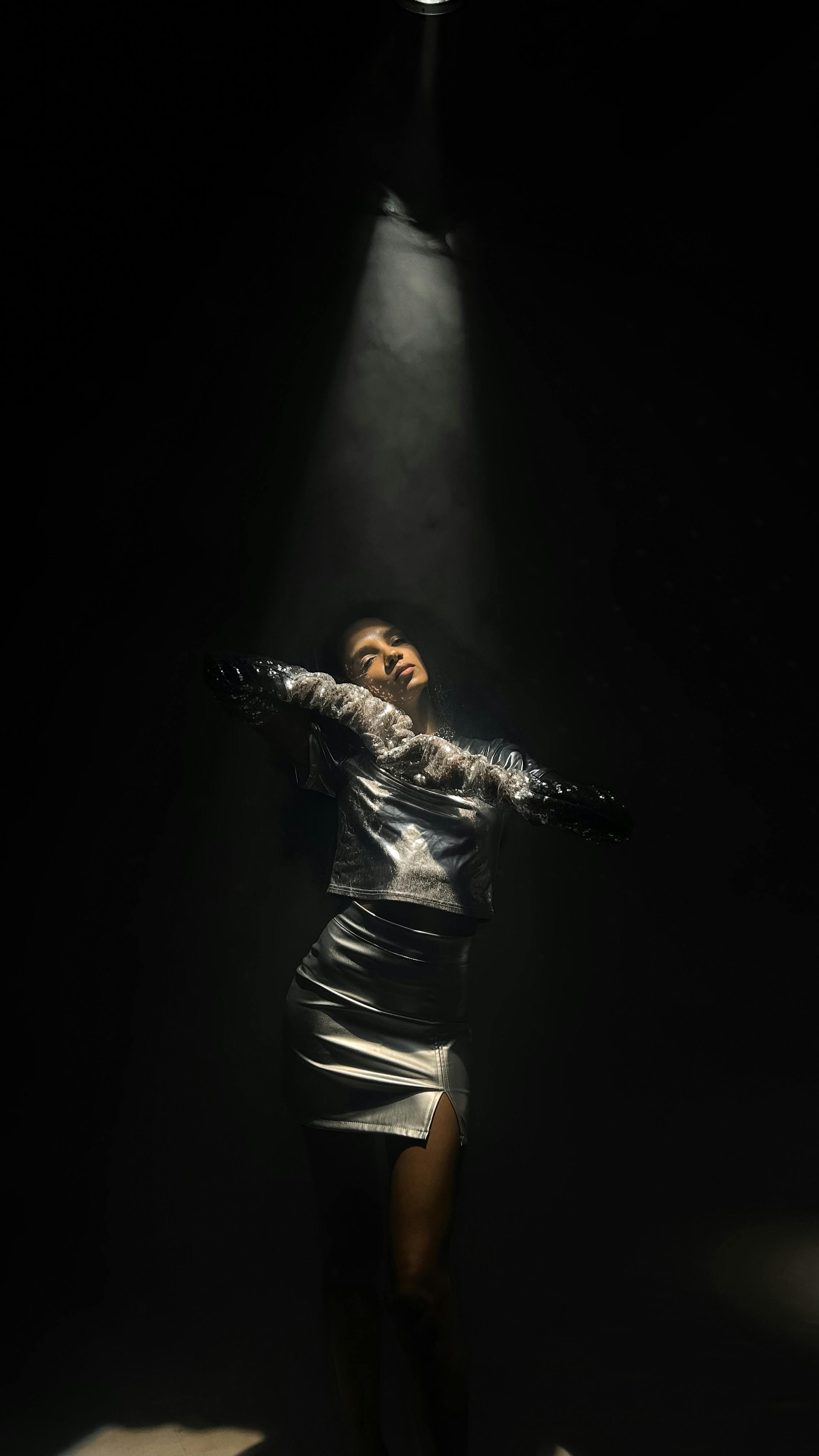 Elegant Woman in Dramatic Spotlight Pose · Free Stock Photo