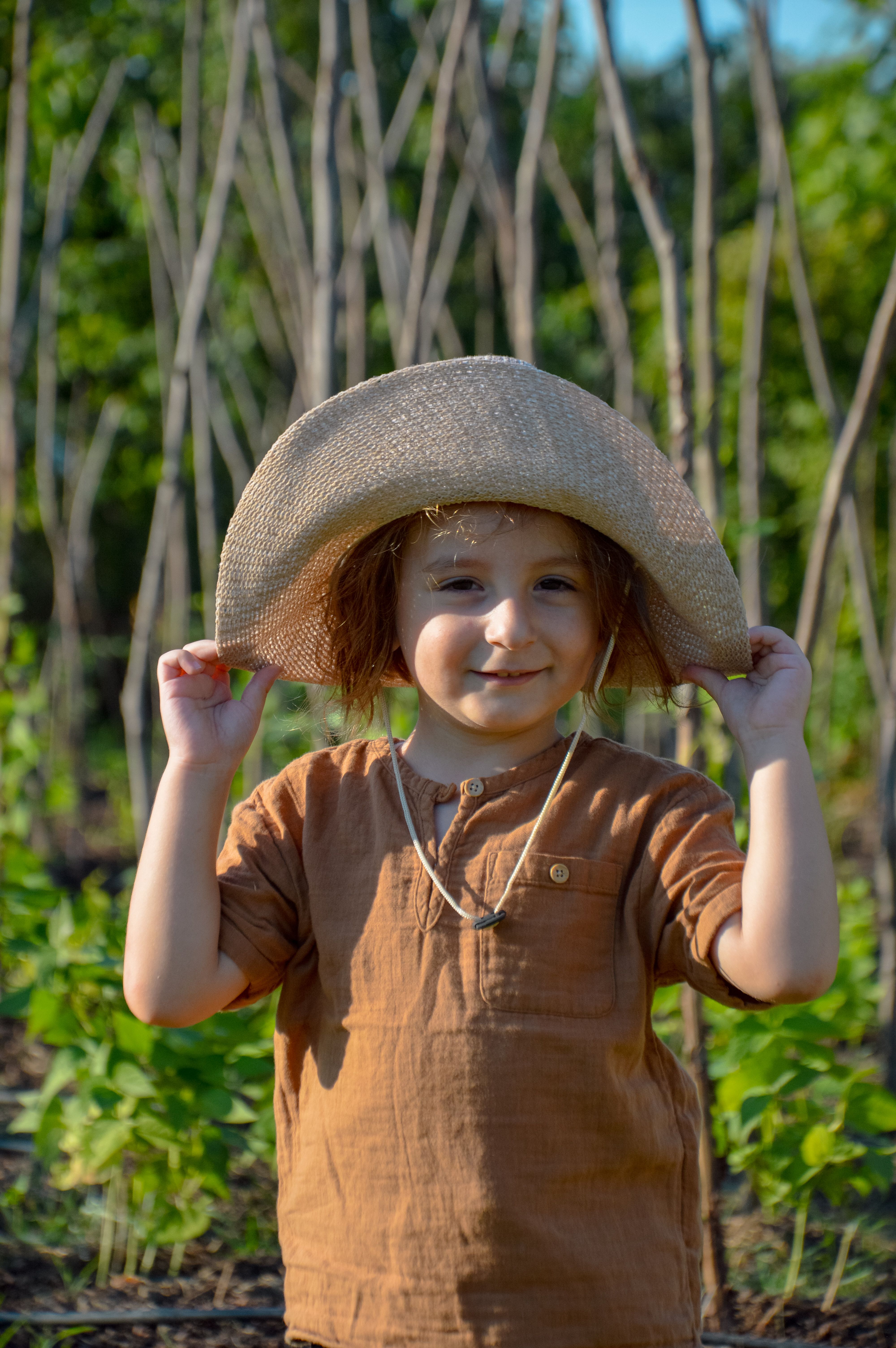 Adorable Child with Straw Hat in Garden · Free Stock Photo
