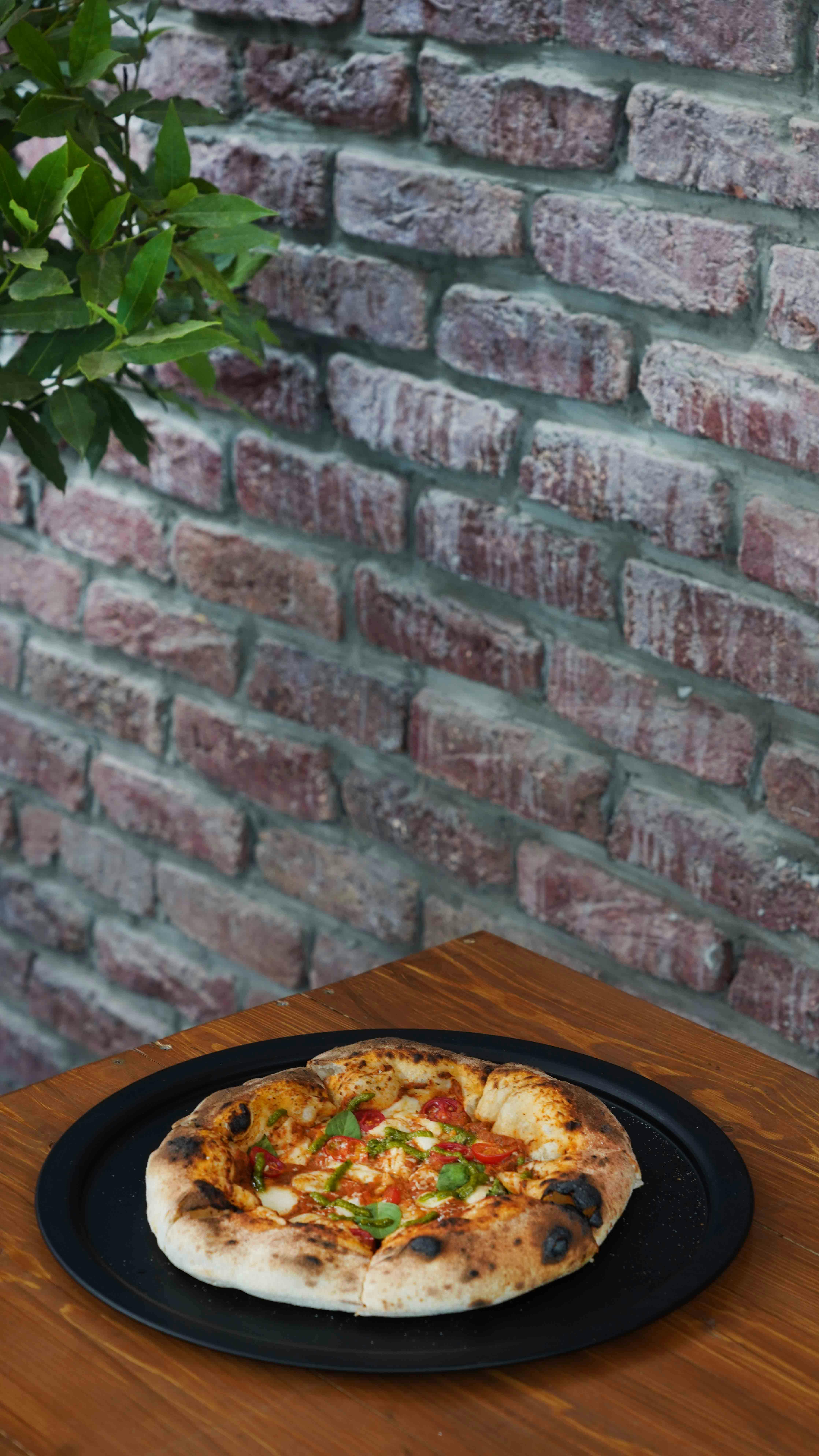 Rustic Neapolitan Pizza on Wooden Table · Free Stock Photo
