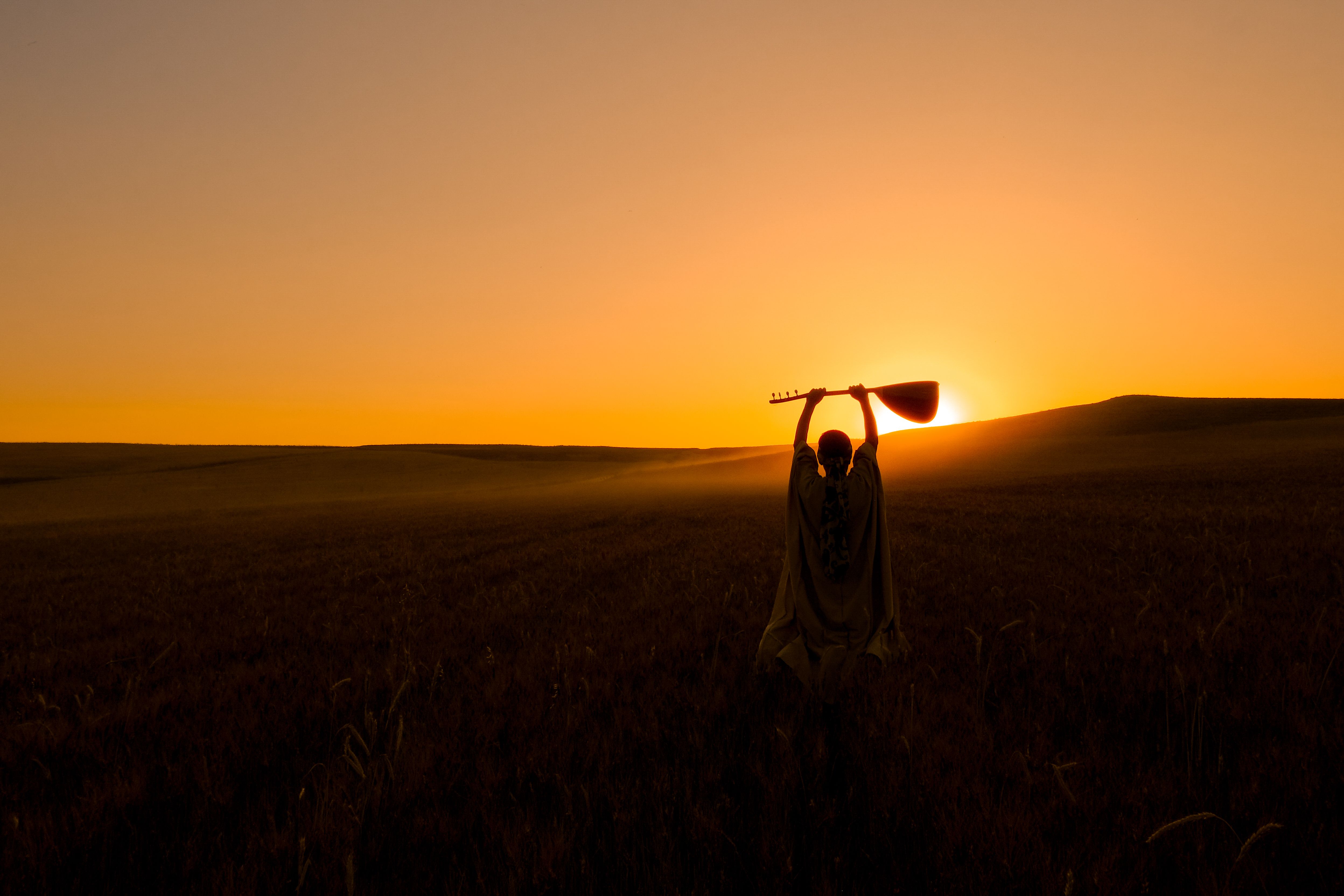 Silhouette of person with instrument at sunset · Free Stock Photo