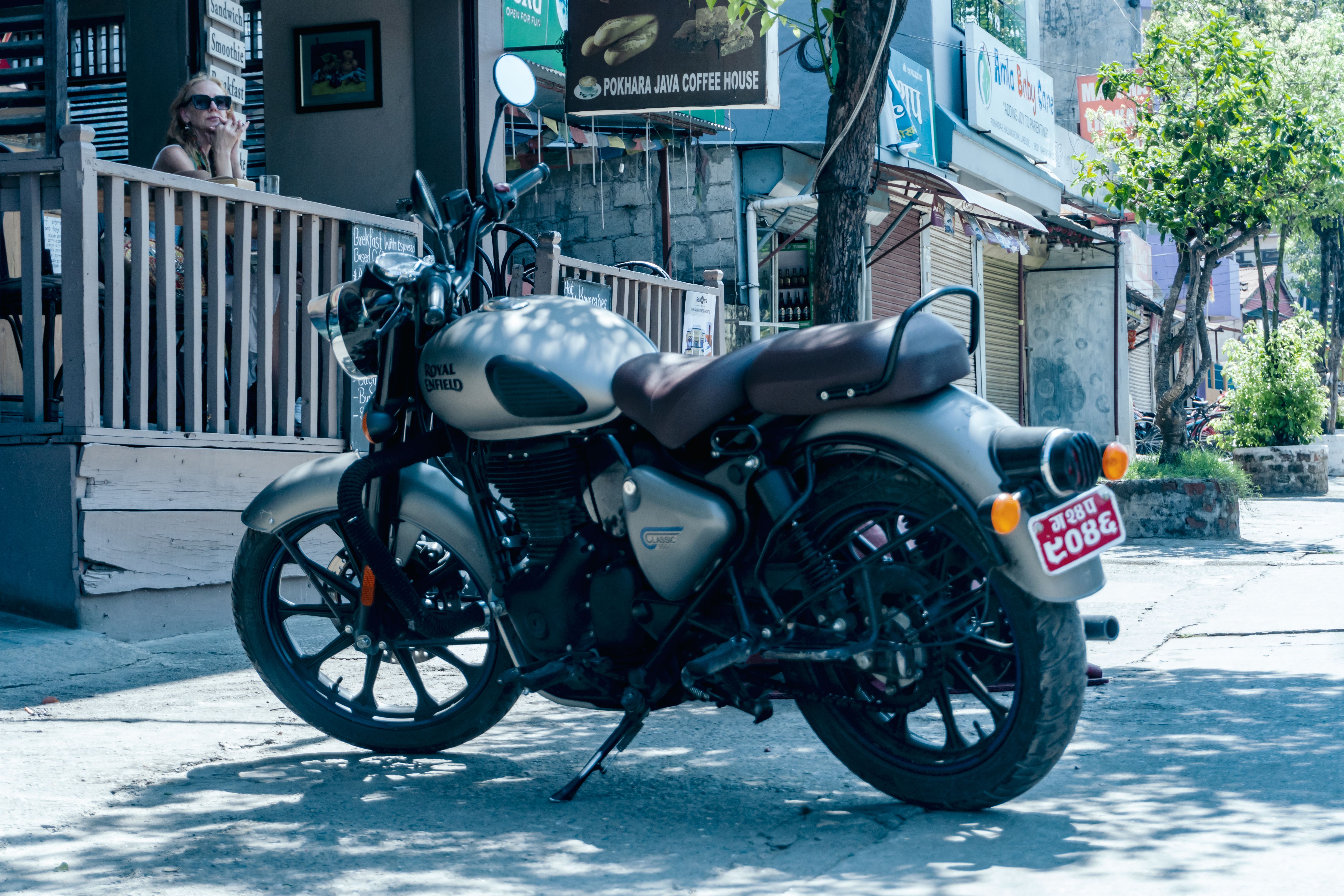 Vintage Royal Enfield Motorcycle Parked Outside Cafe · Free Stock Photo