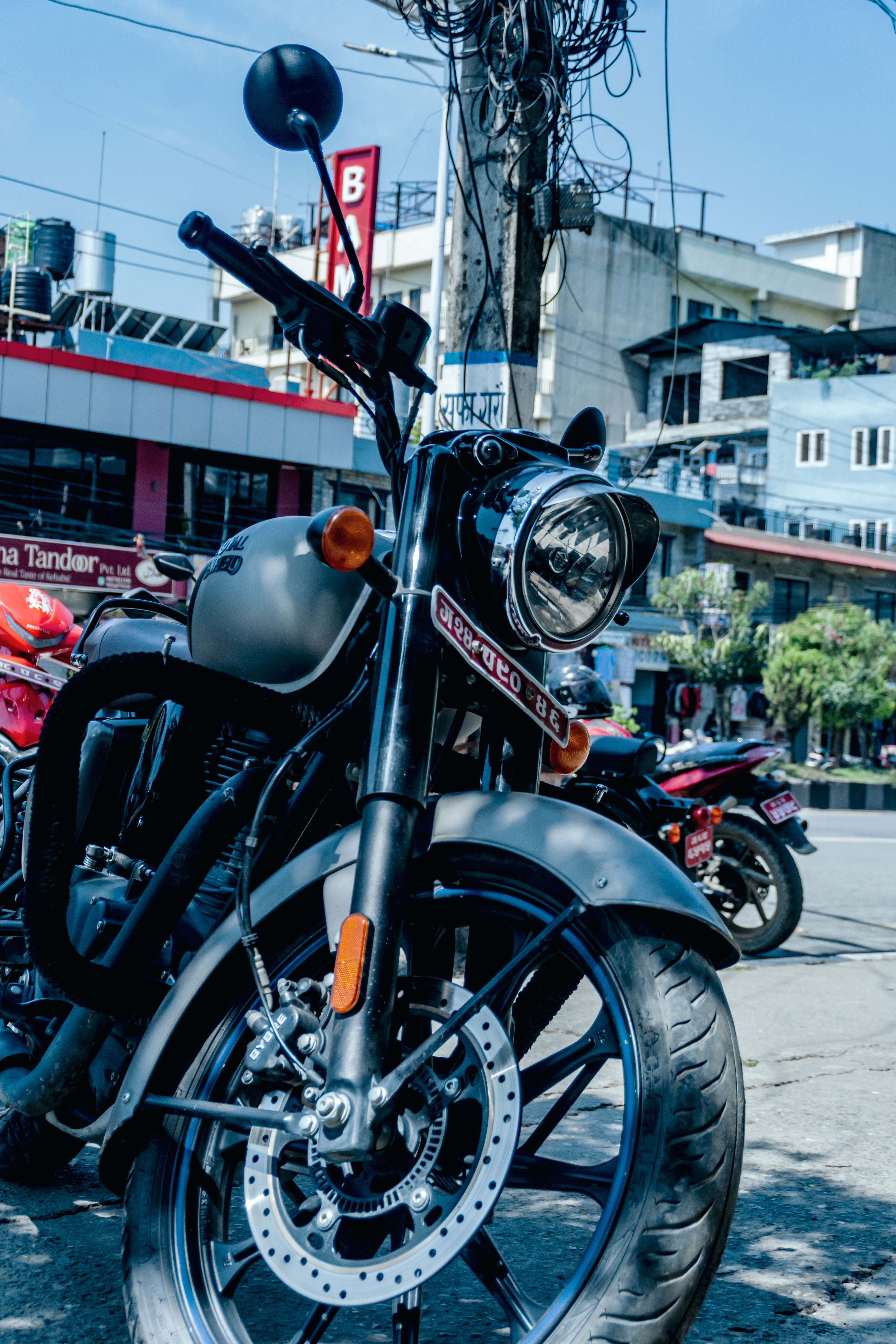 Royal Enfield Motorcycle Parked on Urban Street · Free Stock Photo