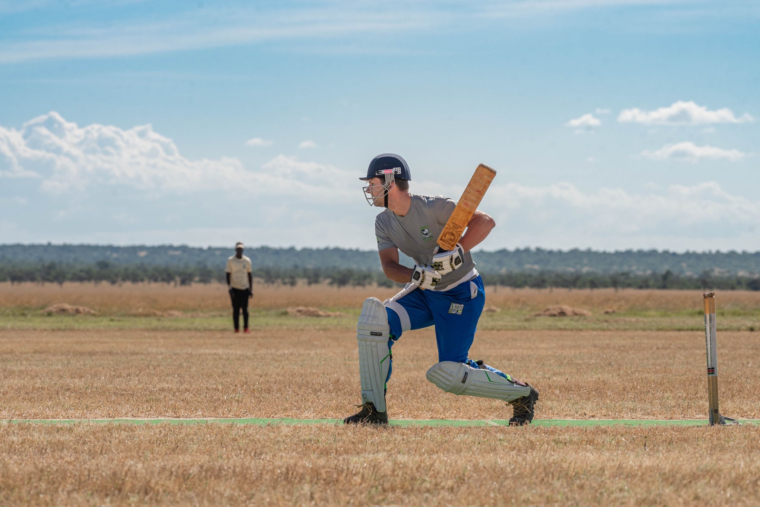 Cricketer in Action on Field with Clear Sky · Free Stock Photo