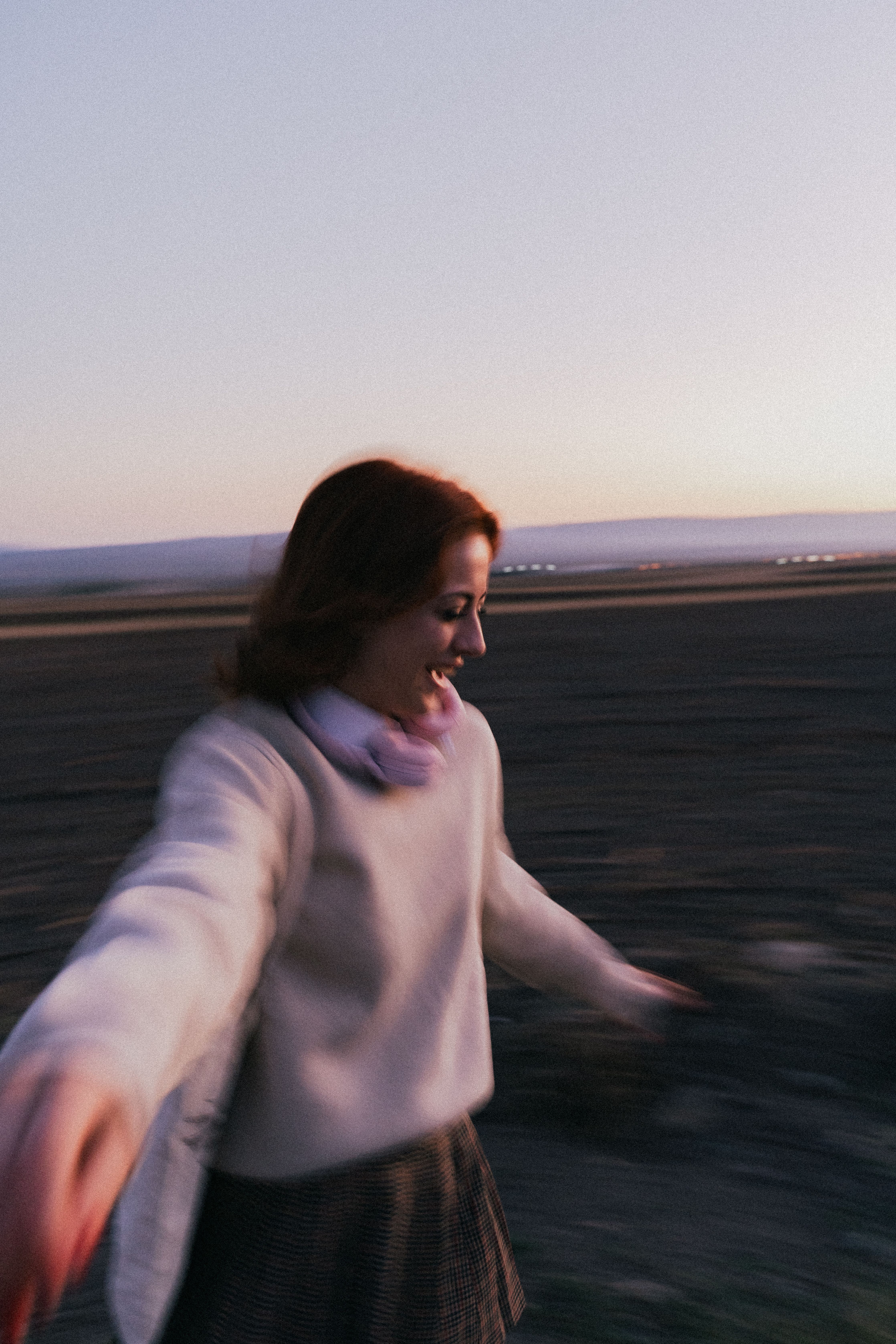 Joyful Woman Spinning Outdoors at Sunset · Free Stock Photo