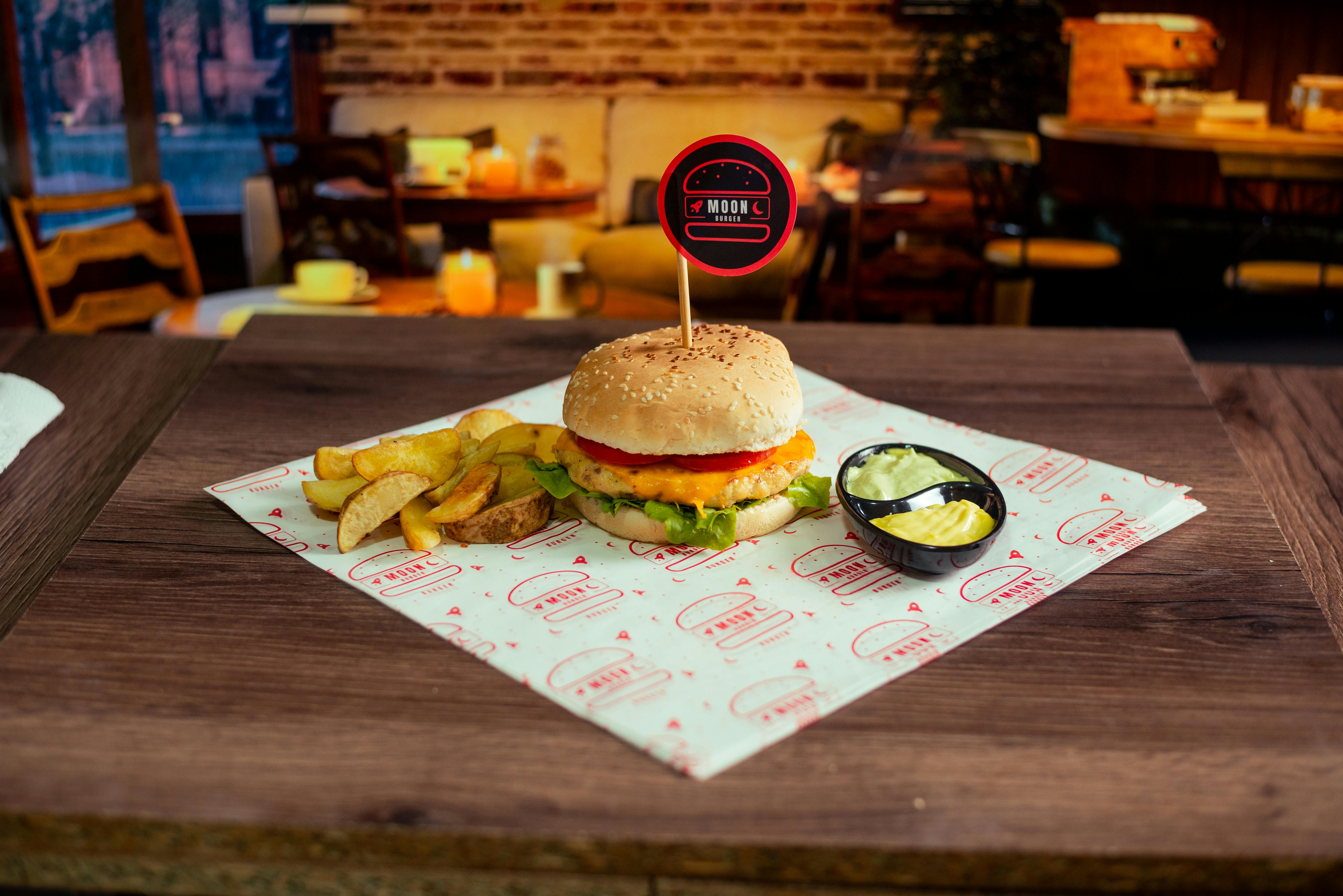 Delicious Burger with Wedges in Cozy Restaurant · Free Stock Photo
