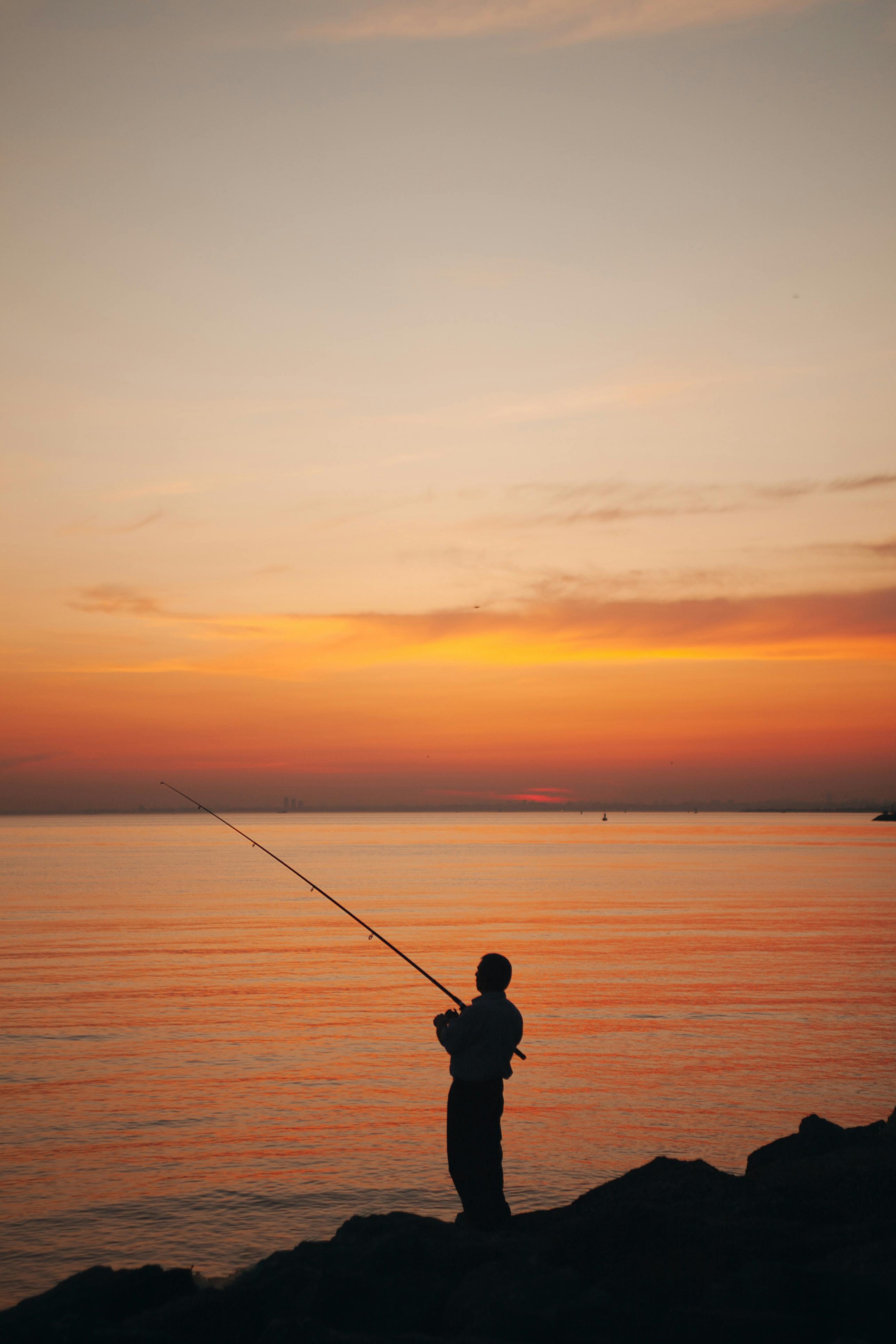 Man Fishing at Sunset by the Ocean · Free Stock Photo