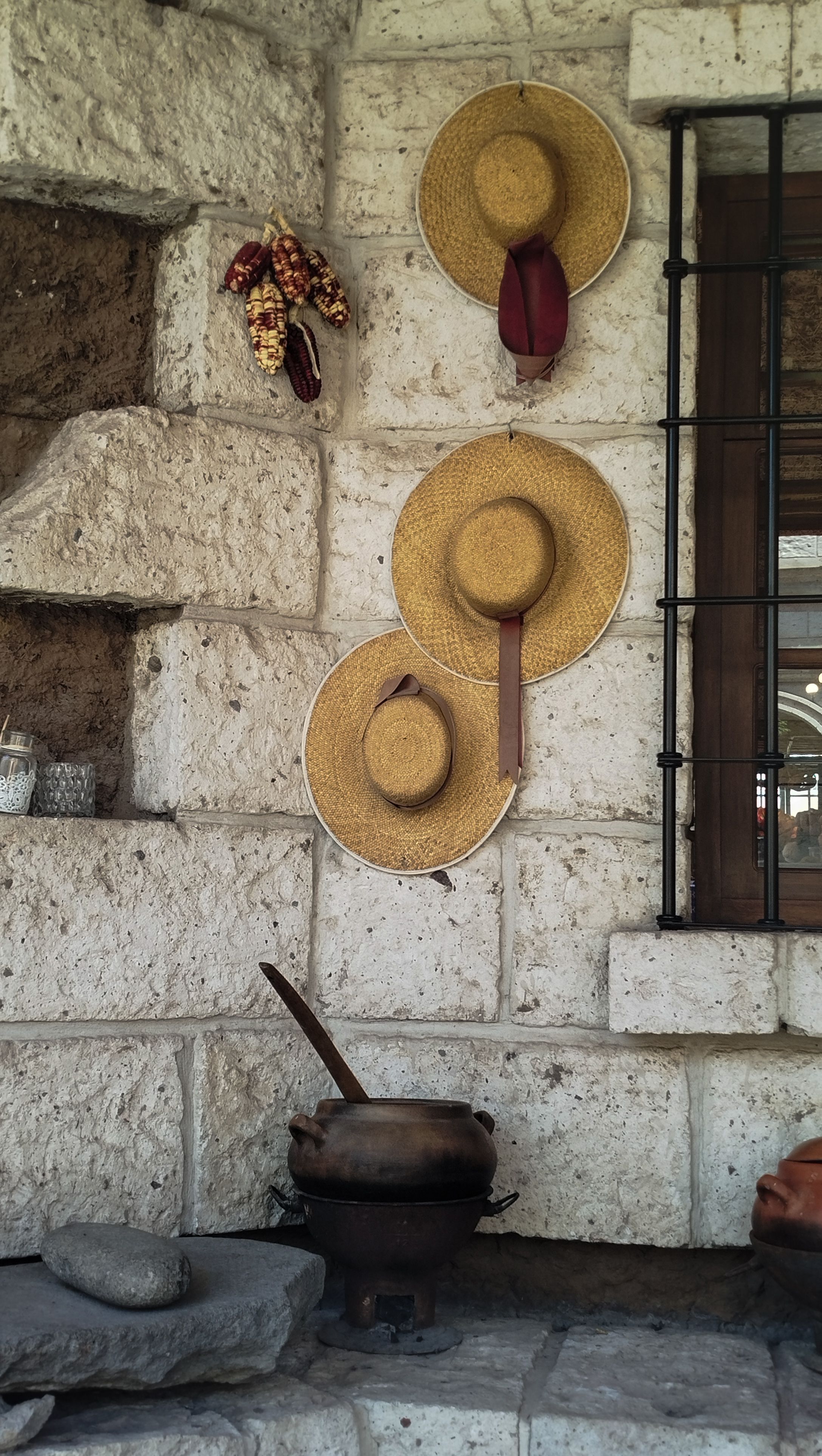 Rustic Stone Wall Decor with Straw Hats · Free Stock Photo