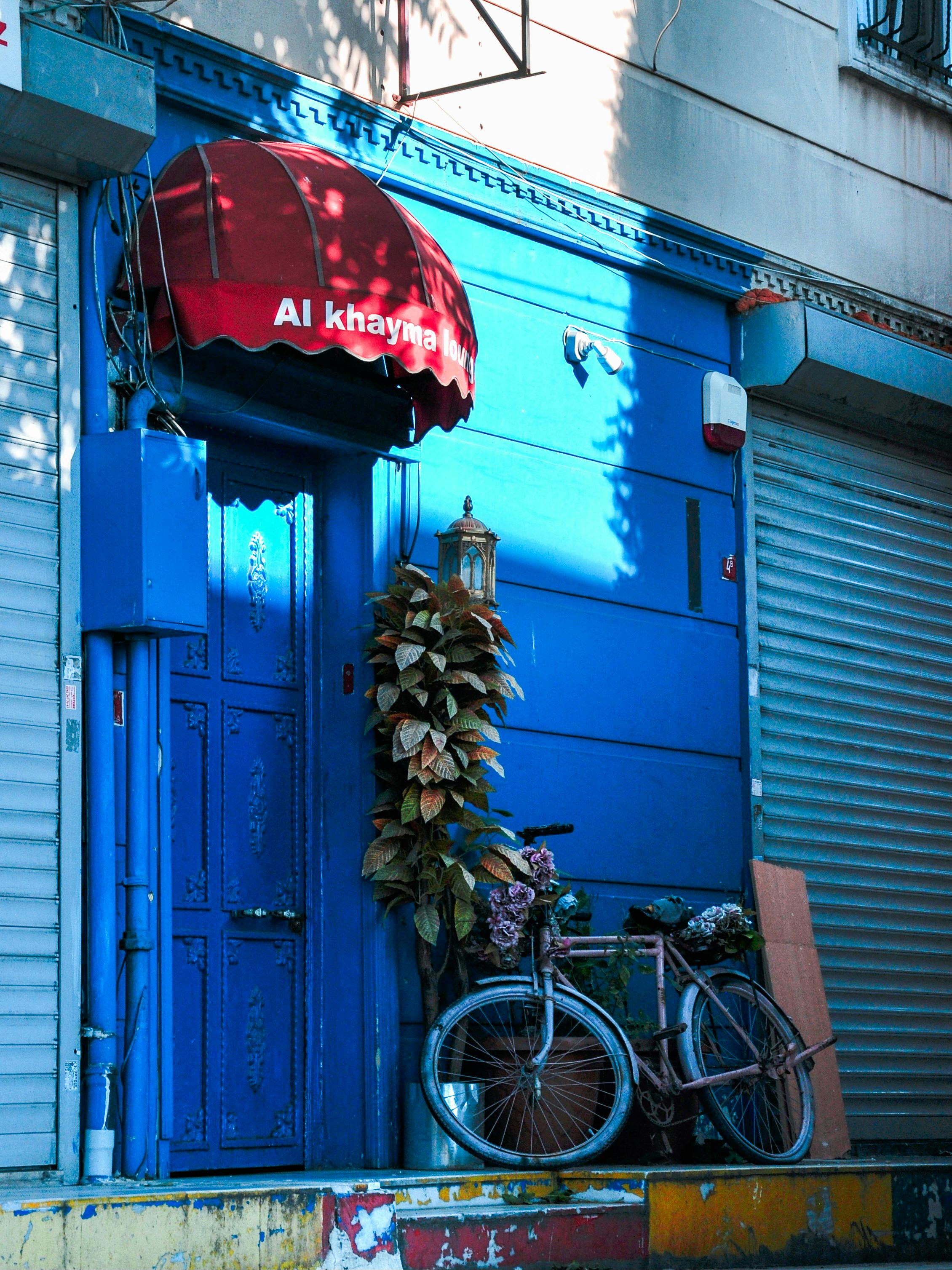 Charming Blue Storefront with Bicycle · Free Stock Photo