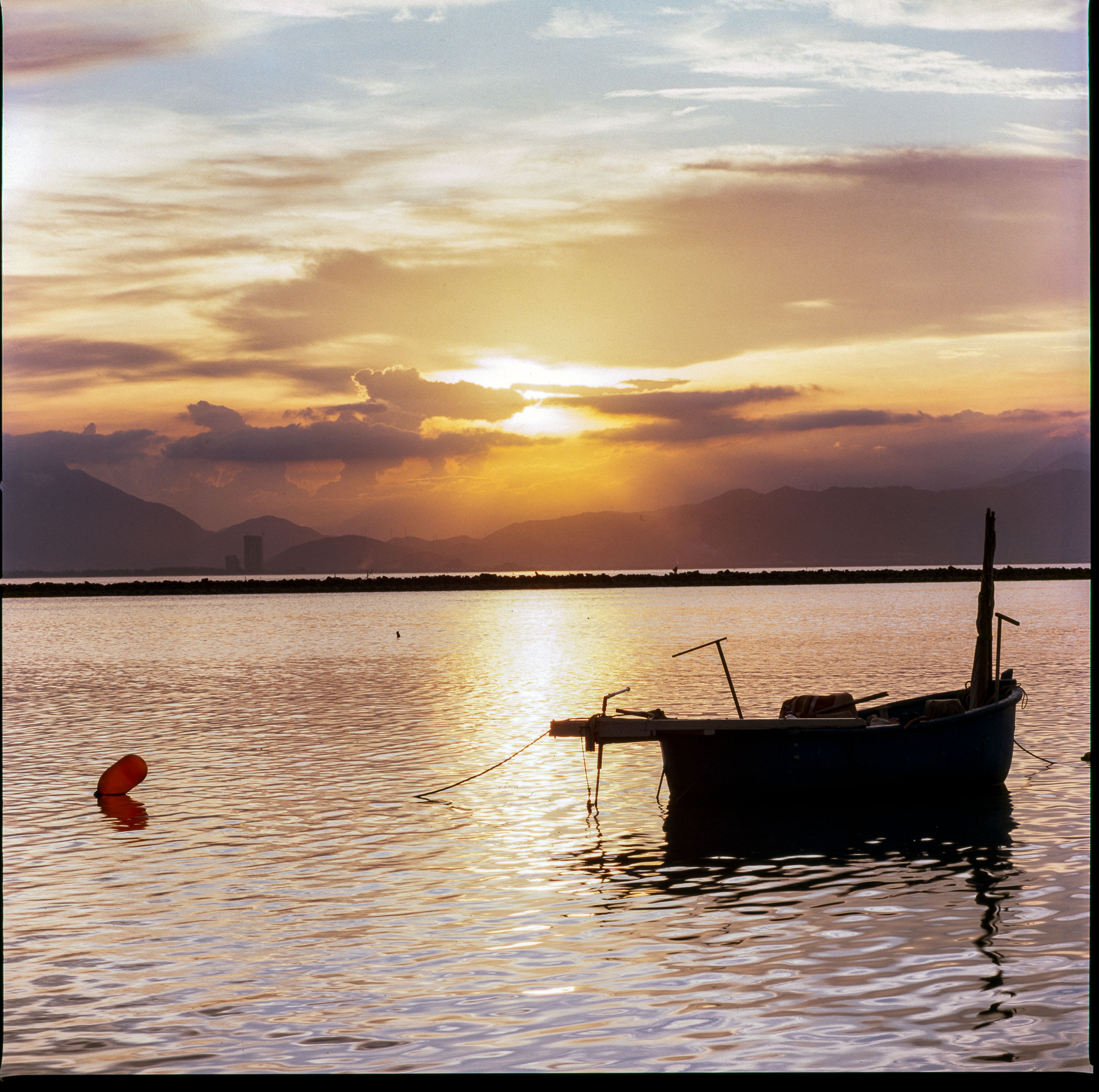Dramatic Sunset Over Calm Sea with Boat · Free Stock Photo