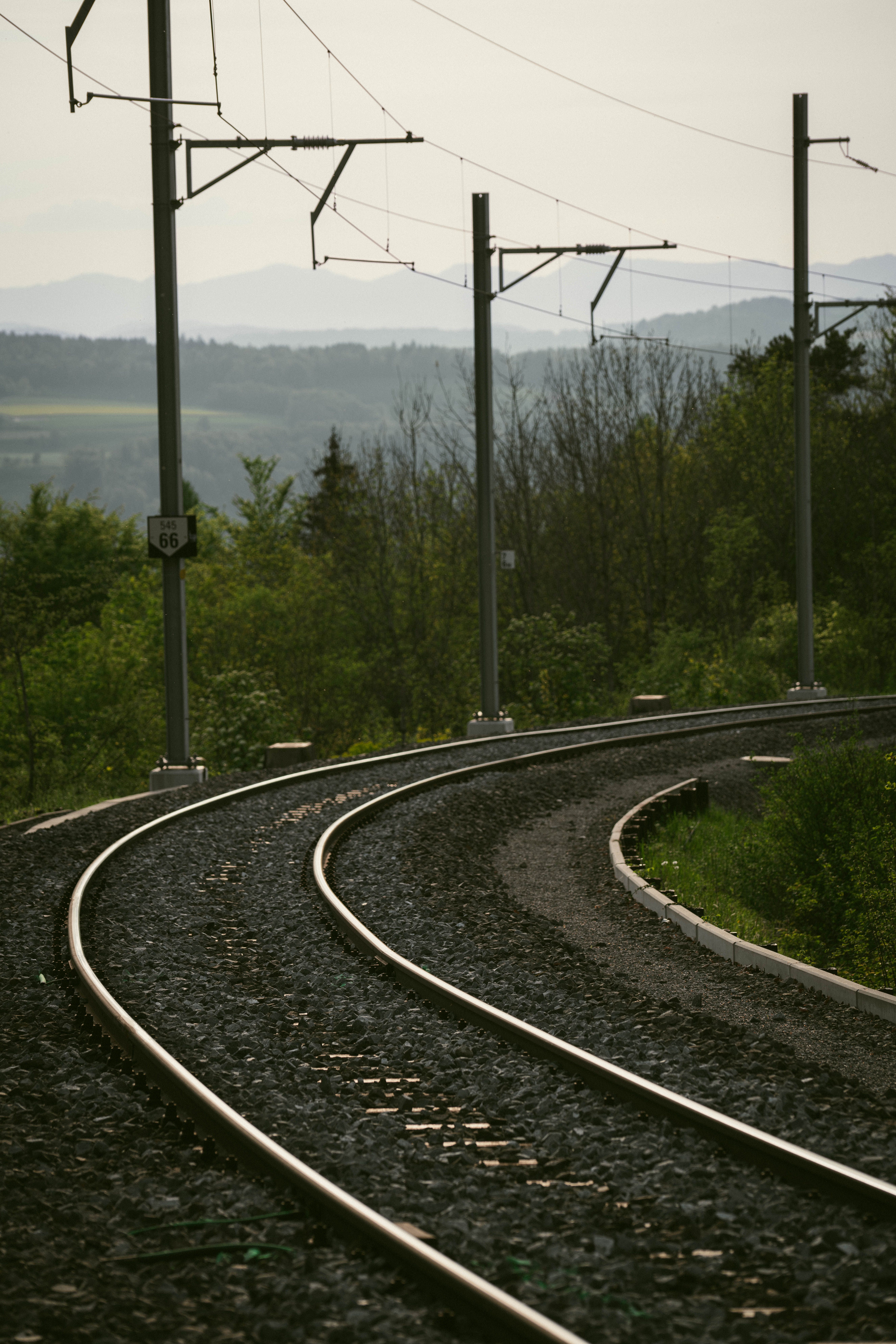 Curved railway tracks in lush green landscape · Free Stock Photo
