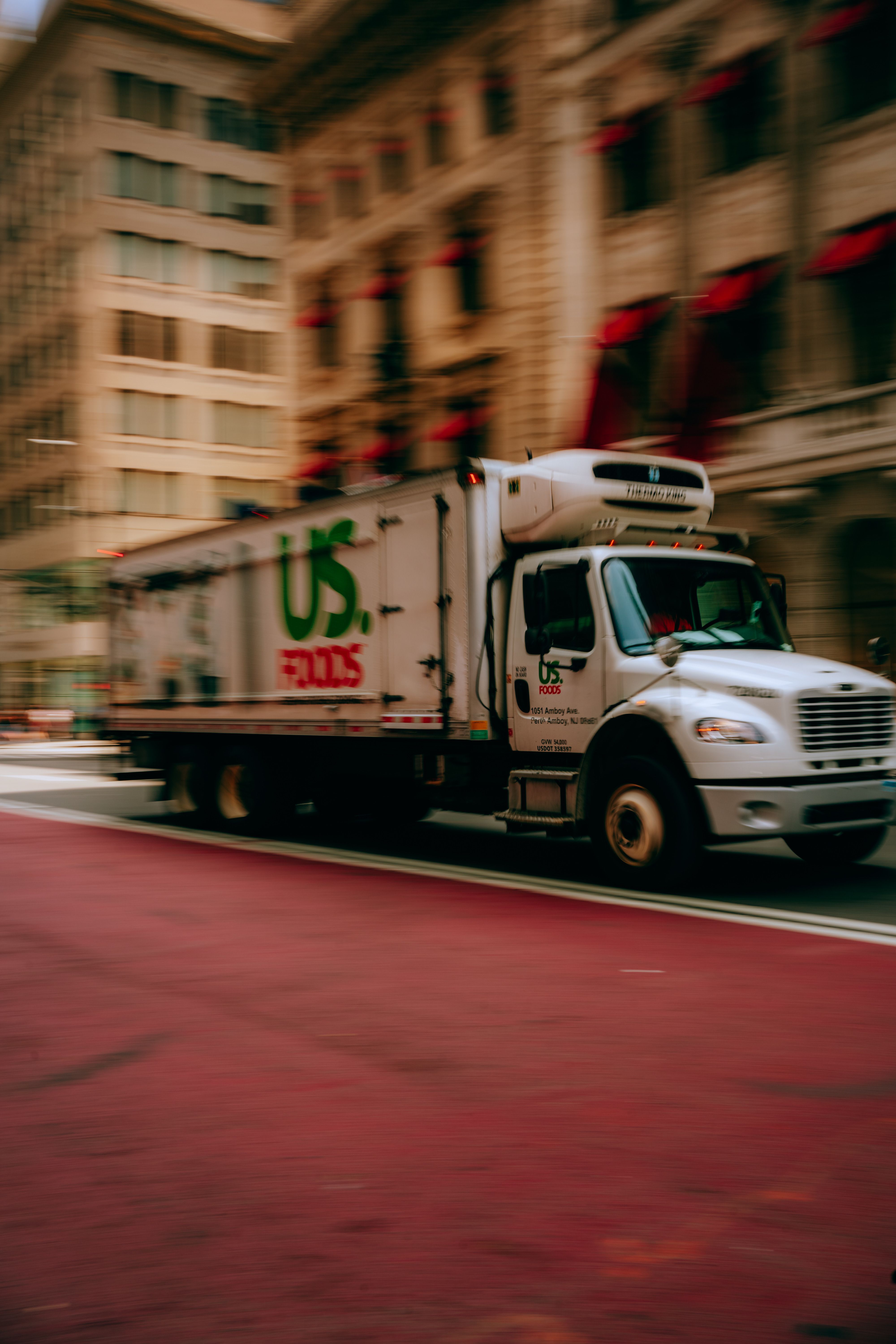 Urban Delivery Truck Driving Through City Street · Free Stock Photo