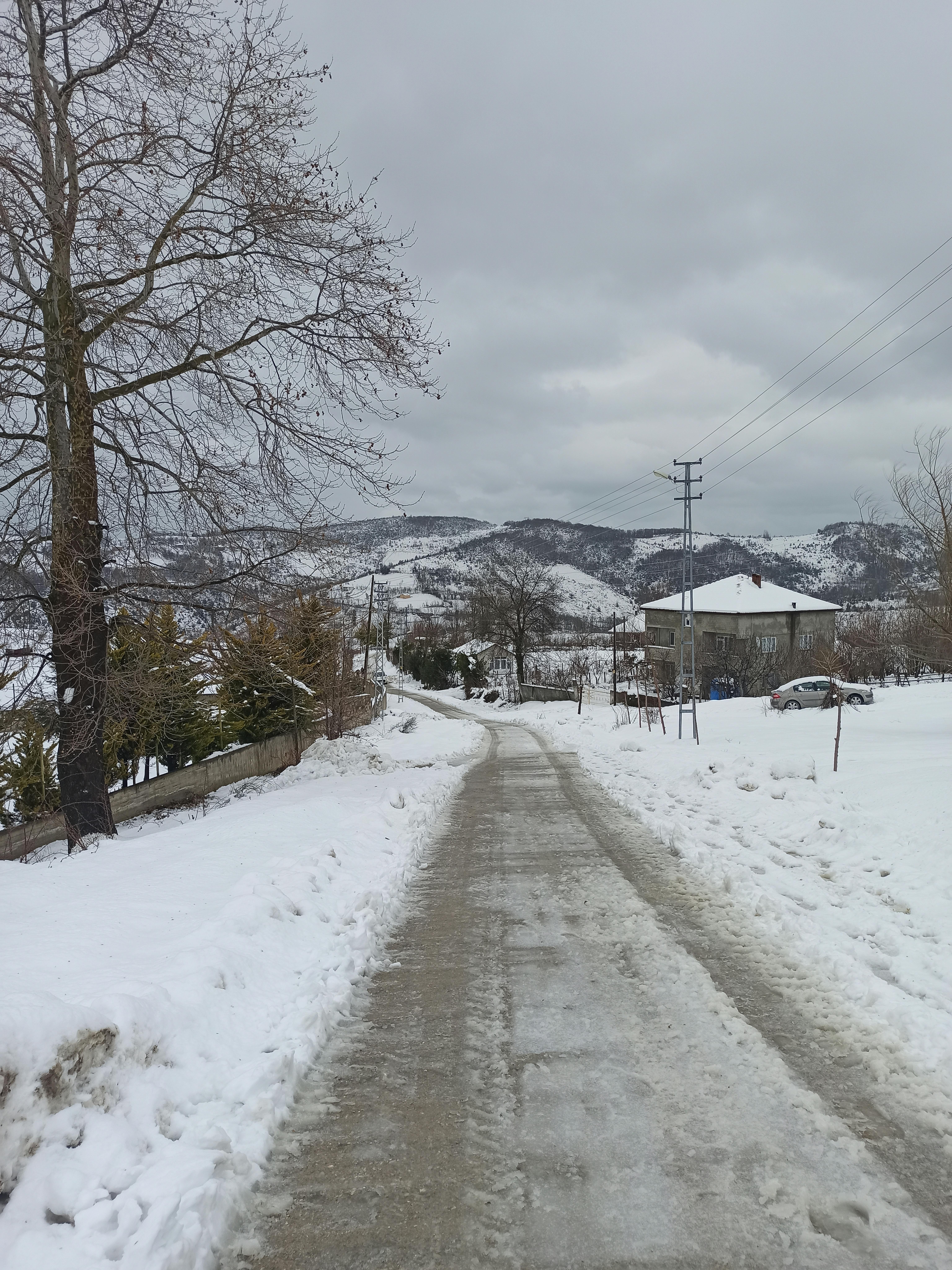 Snowy winter road through rural village landscape · Free Stock Photo