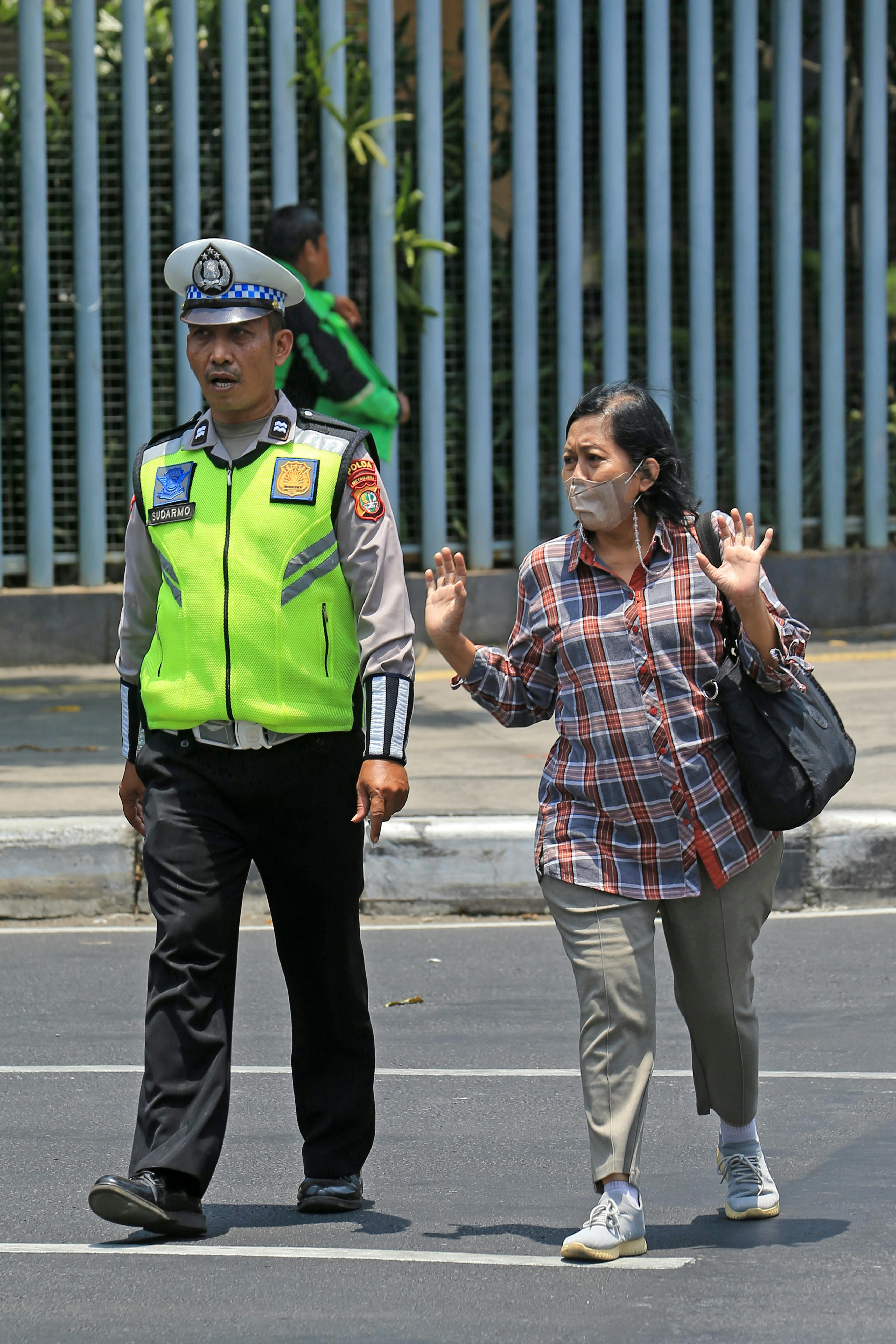 Police Officer Assisting Pedestrian on City Street · Free Stock Photo