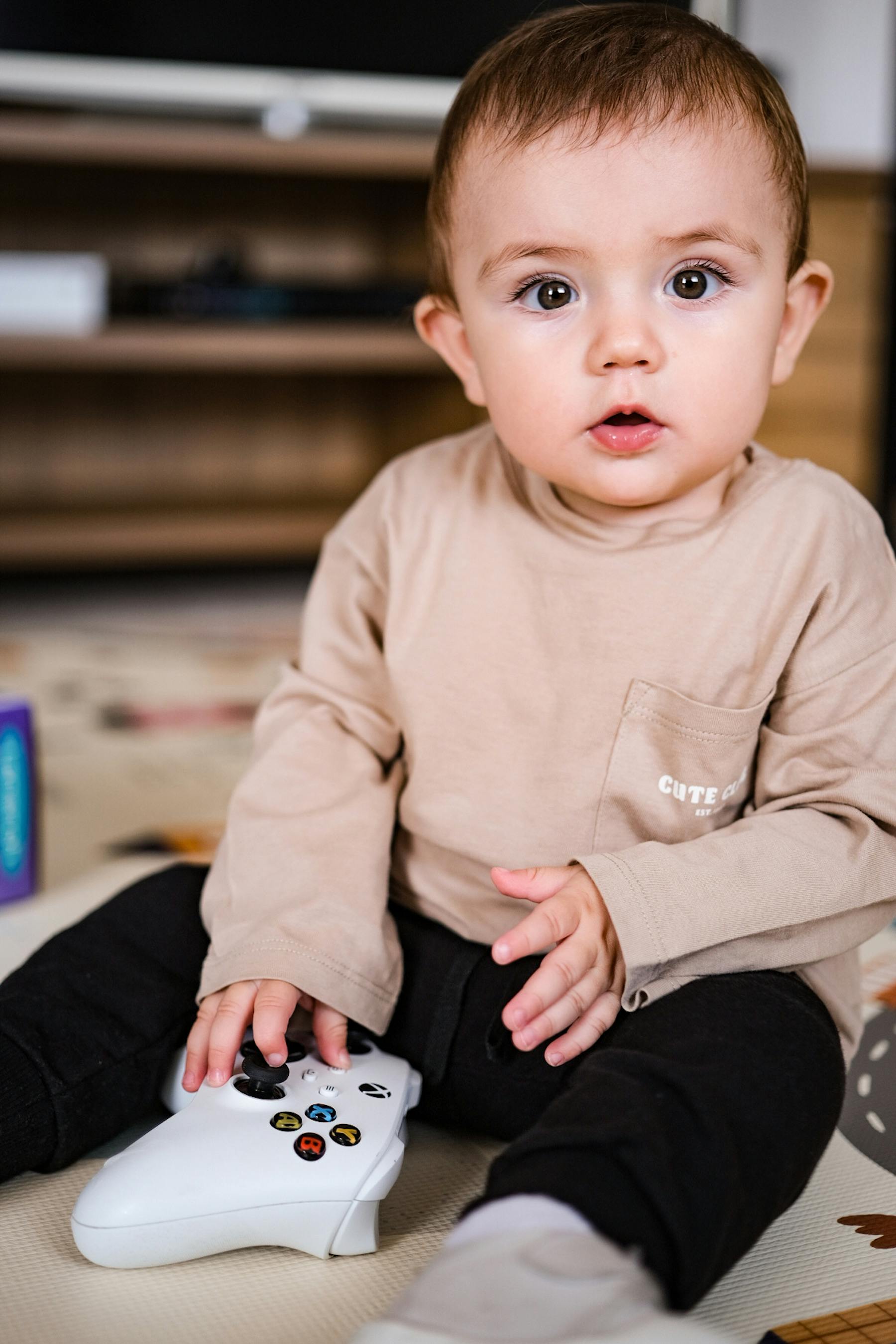Adorable Baby Playing with Game Controller Indoors · Free Stock Photo