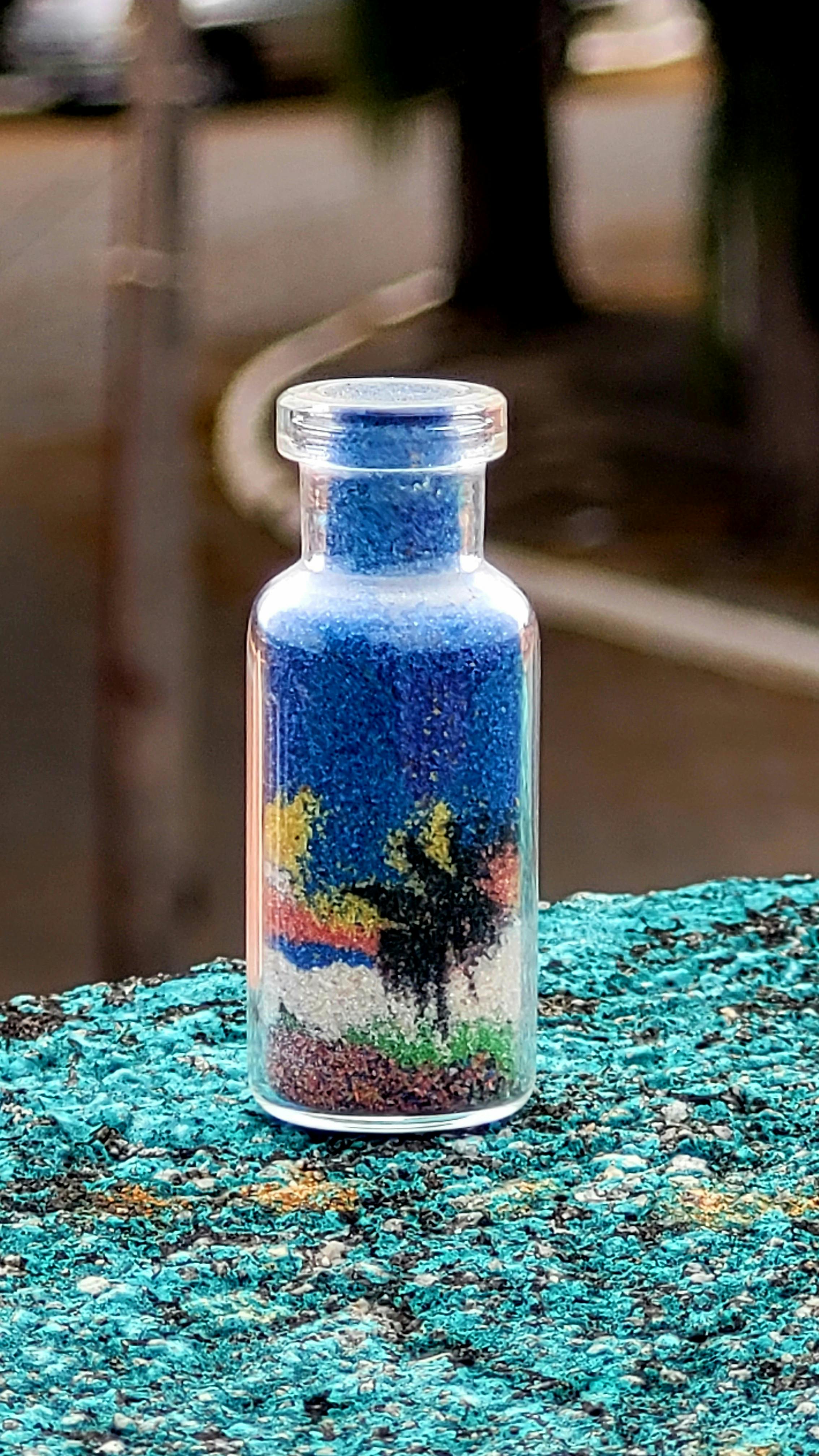 Colorful Sand Art Bottle on Textured Surface · Free Stock Photo
