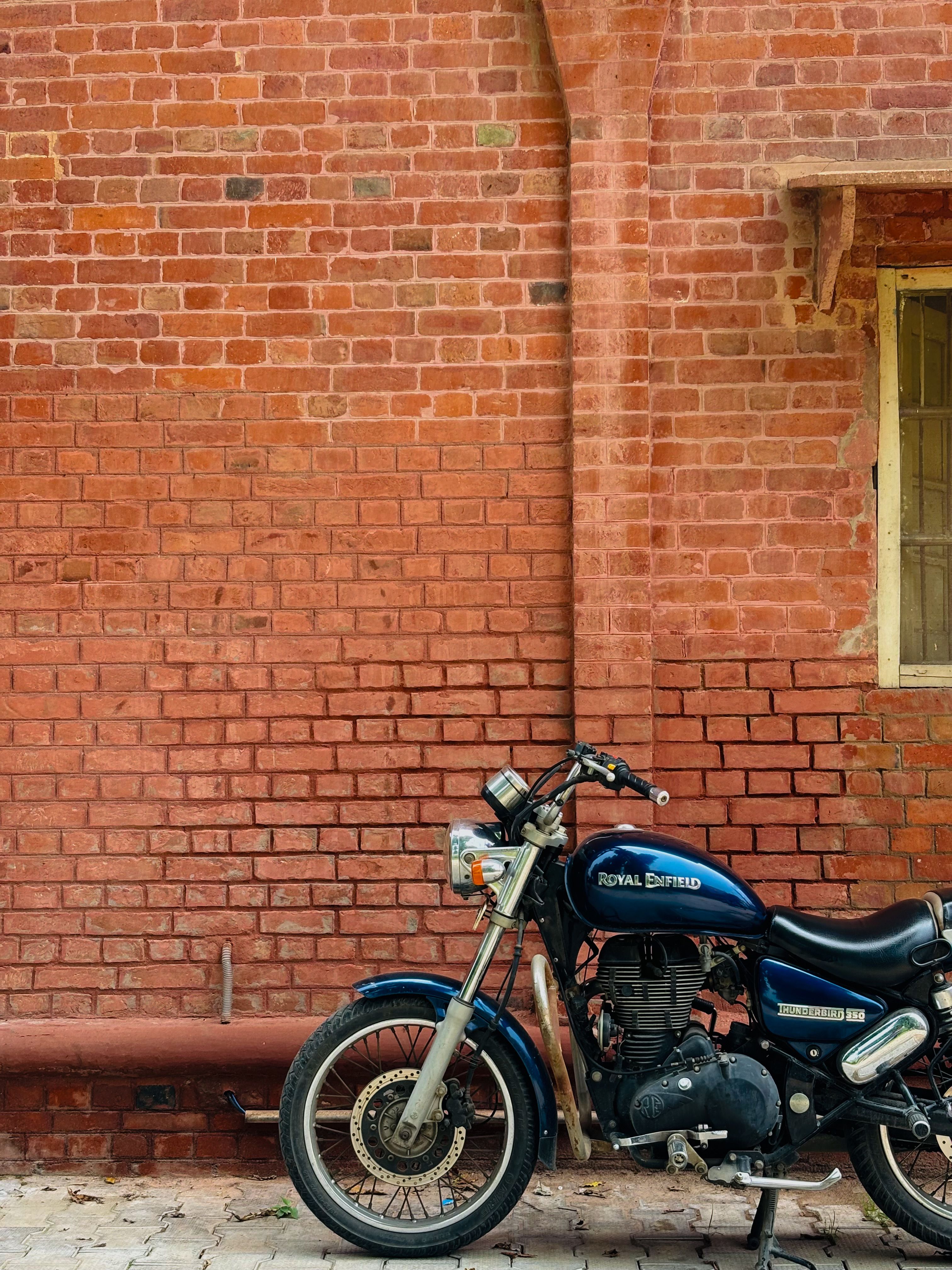 Royal Enfield Motorcycle Against Brick Wall · Free Stock Photo