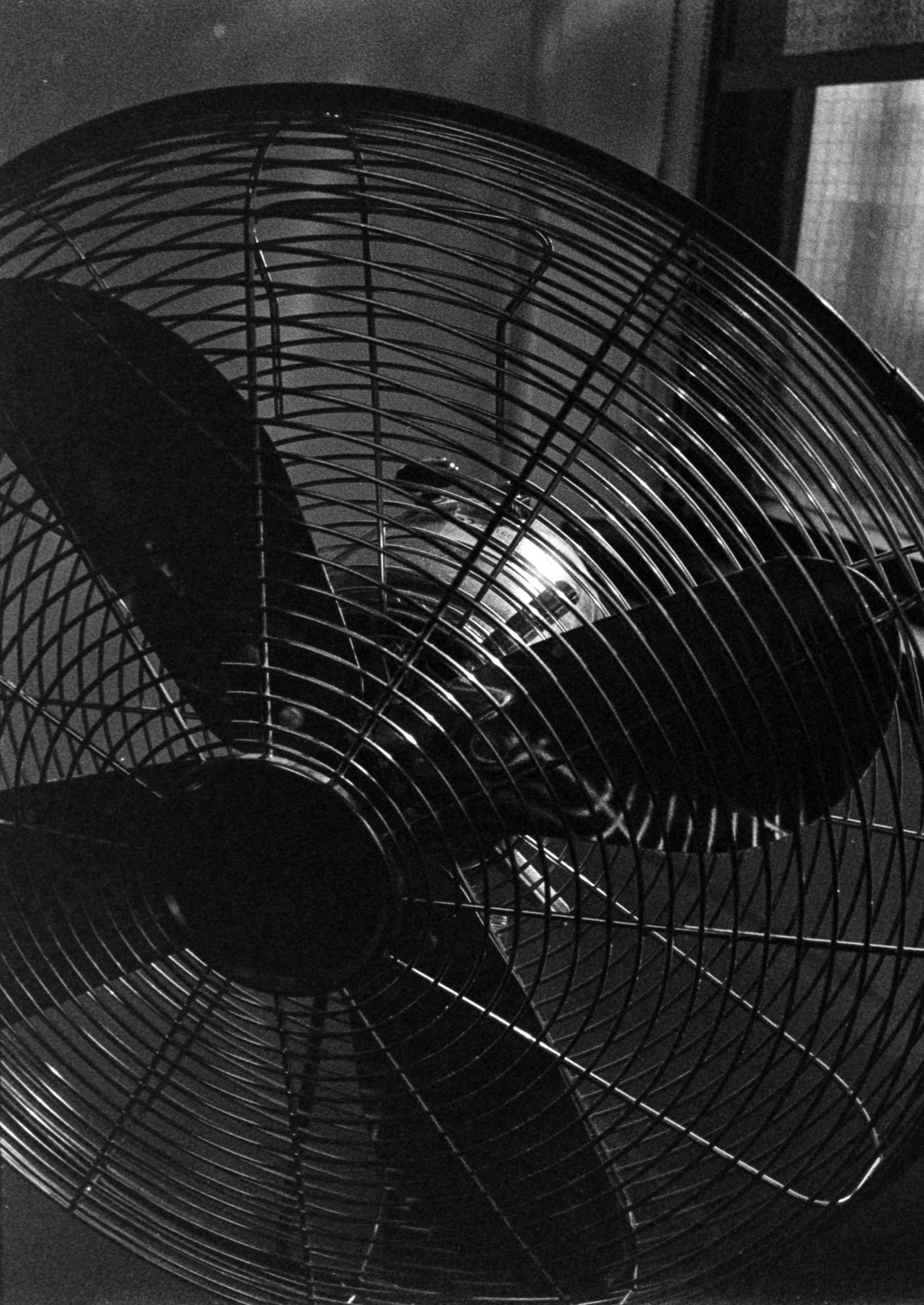 Close-up of a Vintage Oscillating Fan in Shadows · Free Stock Photo