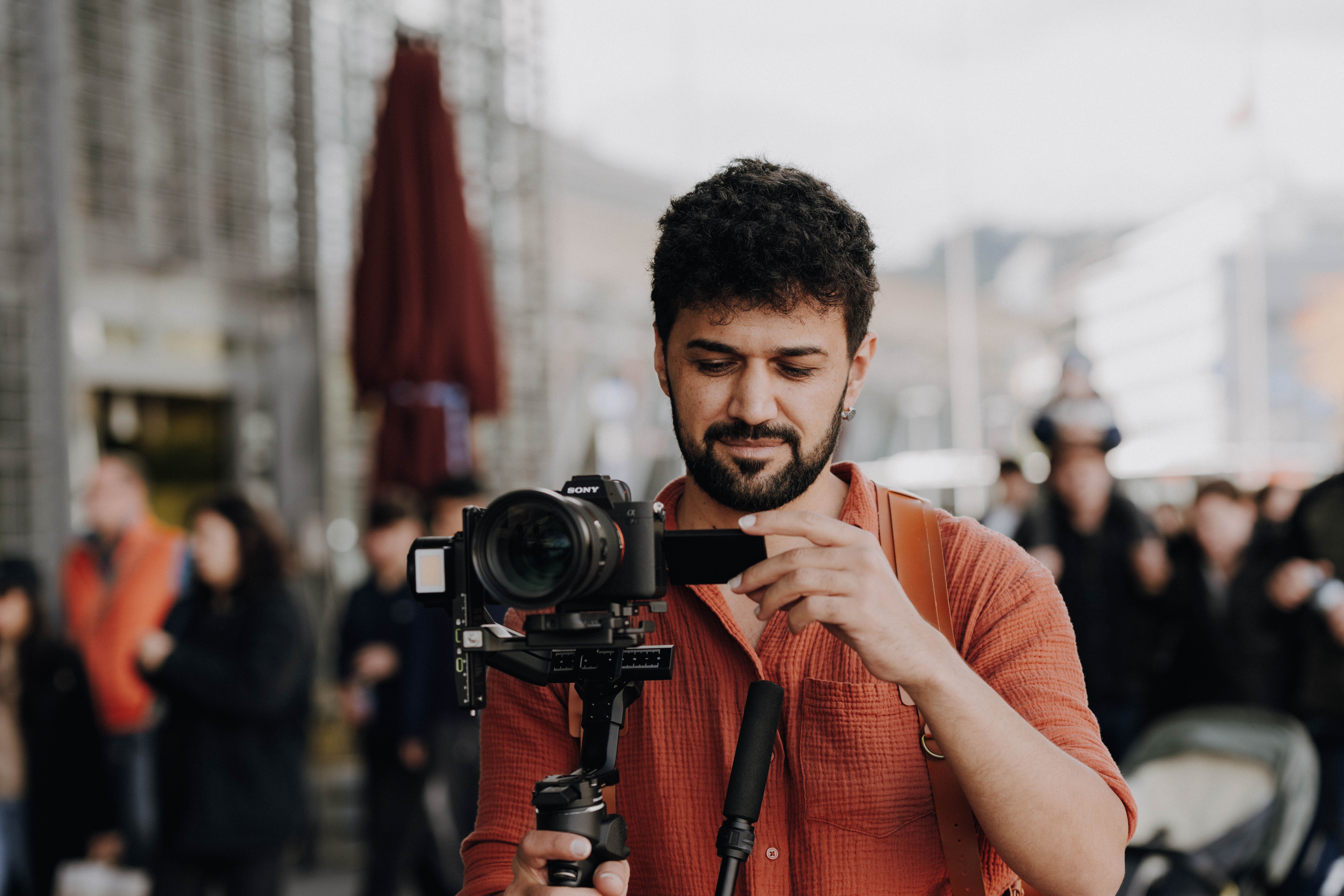 Photographer Outdoors Filming with Camera · Free Stock Photo
