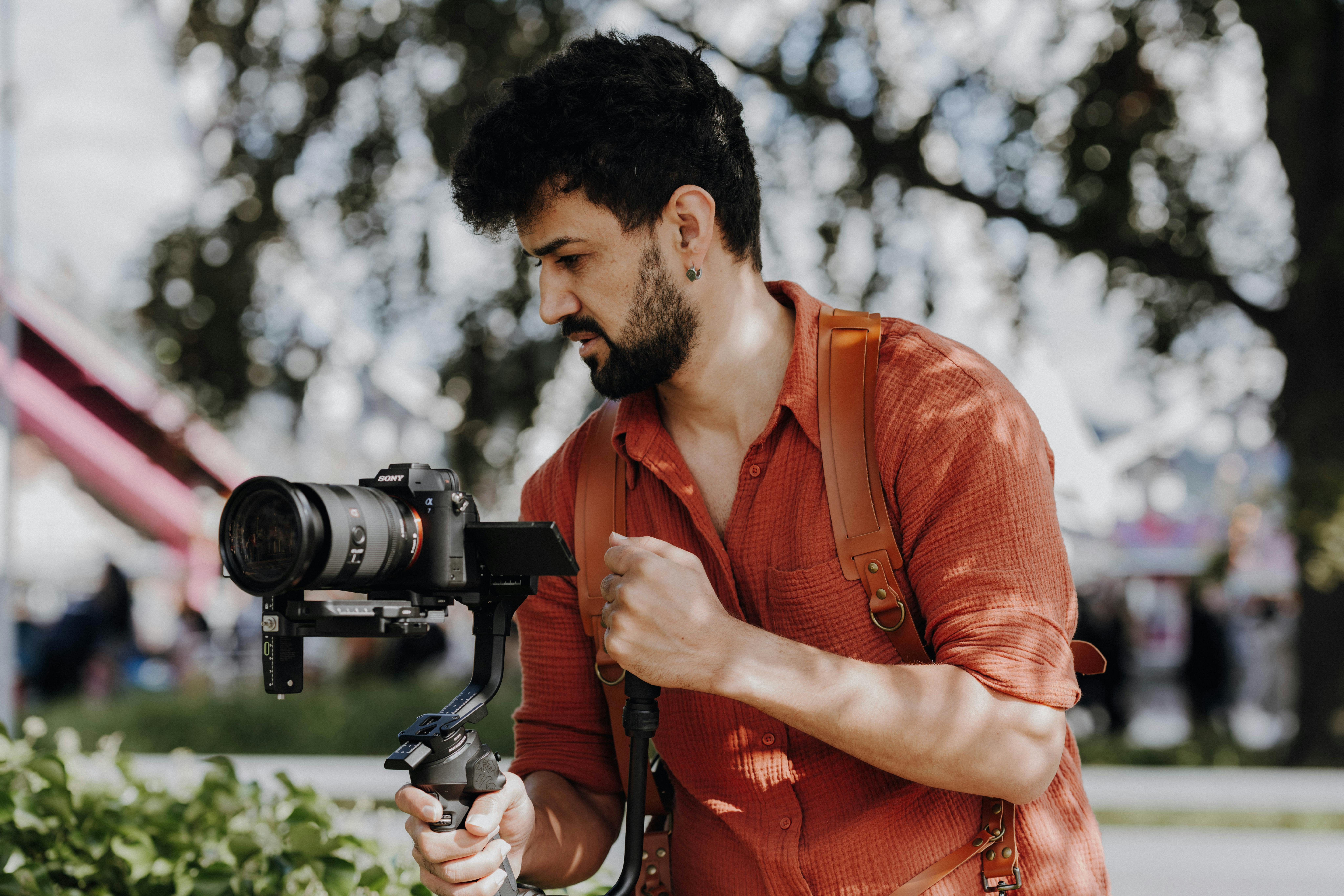 Man Filming Outdoors with Professional Camera Gear · Free Stock Photo