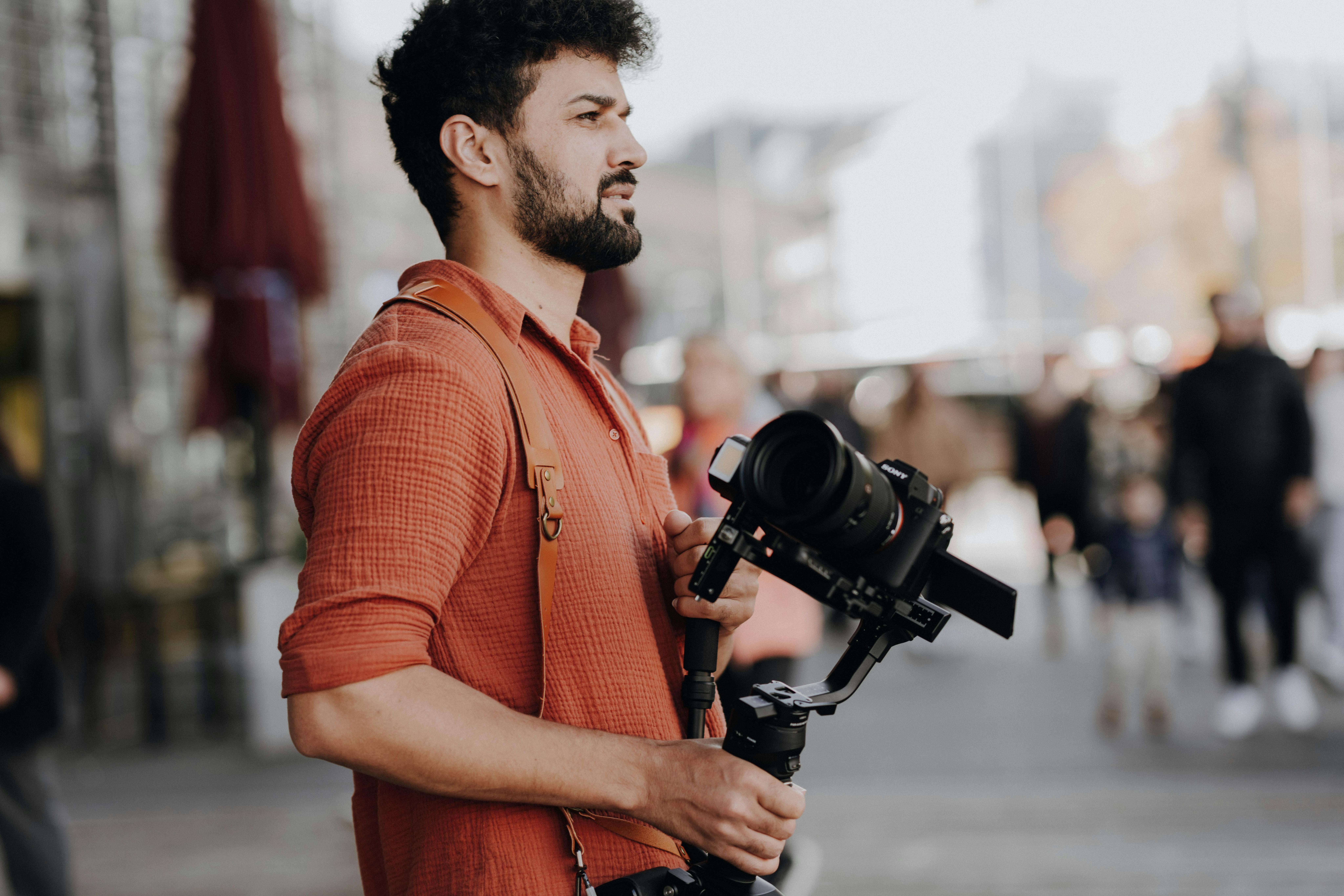 Male Videographer Filming in Urban Setting · Free Stock Photo