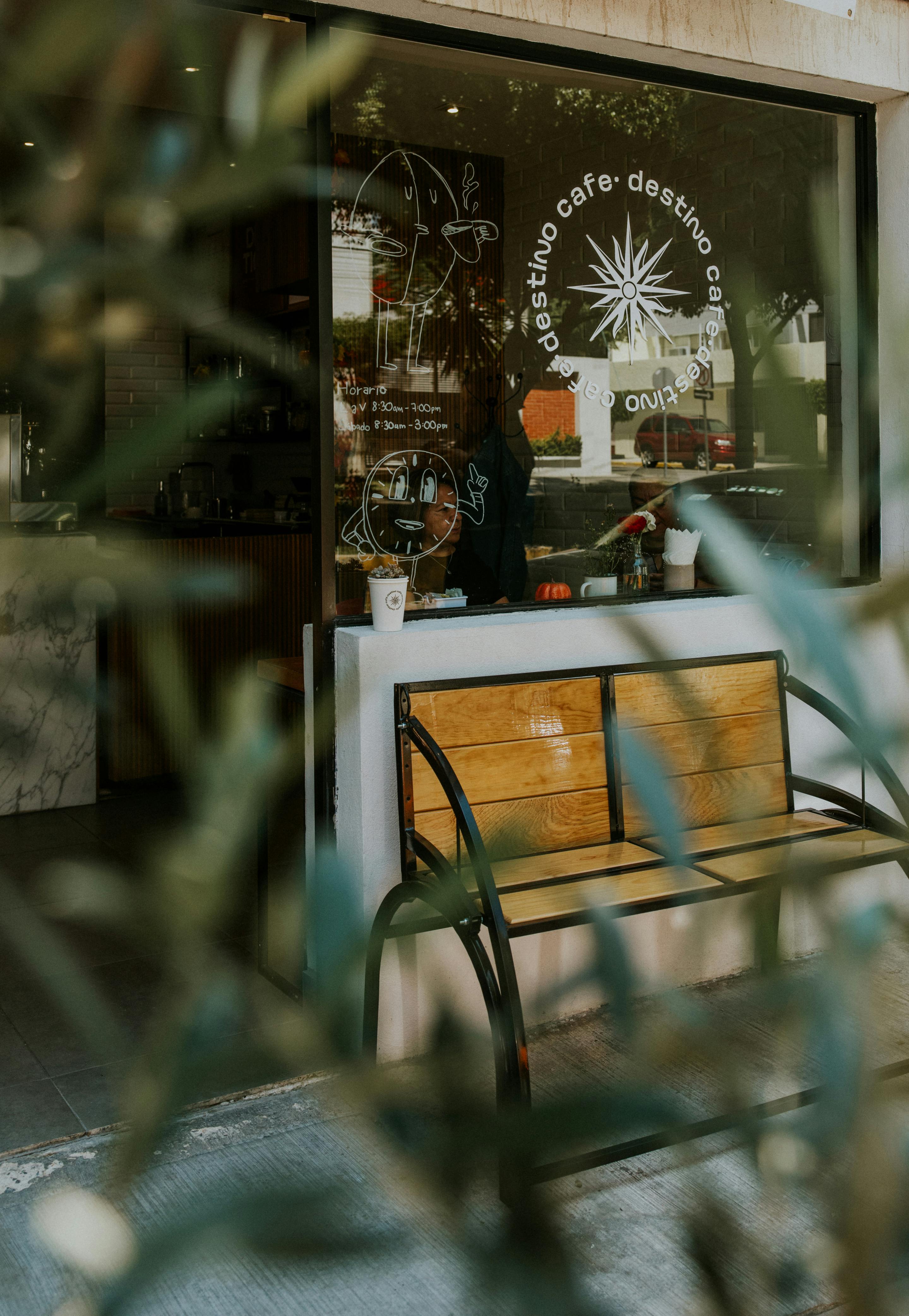 Charming Outdoor Cafe with Wooden Bench · Free Stock Photo