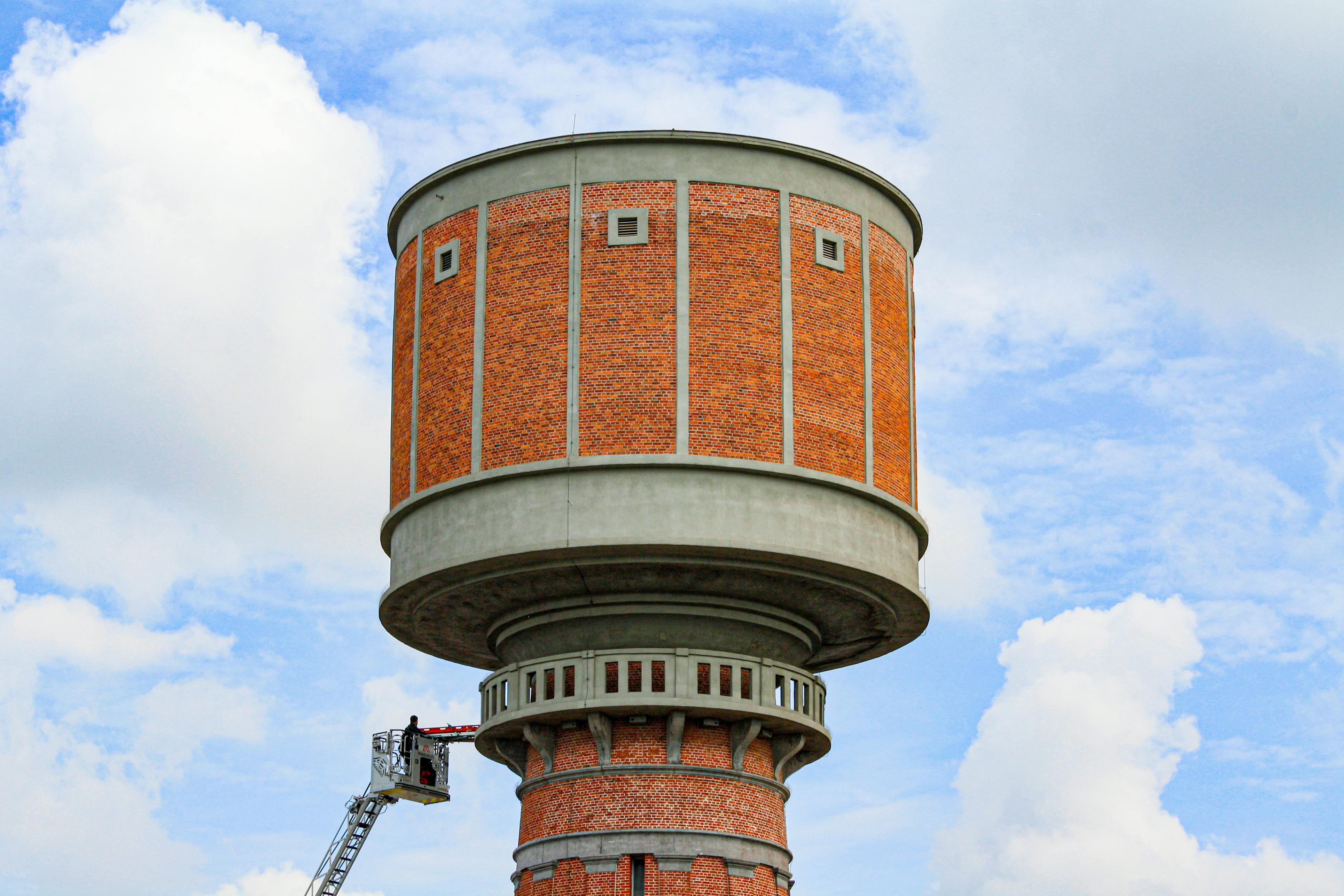 Historic Brick Water Tower Against Blue Sky · Free Stock Photo