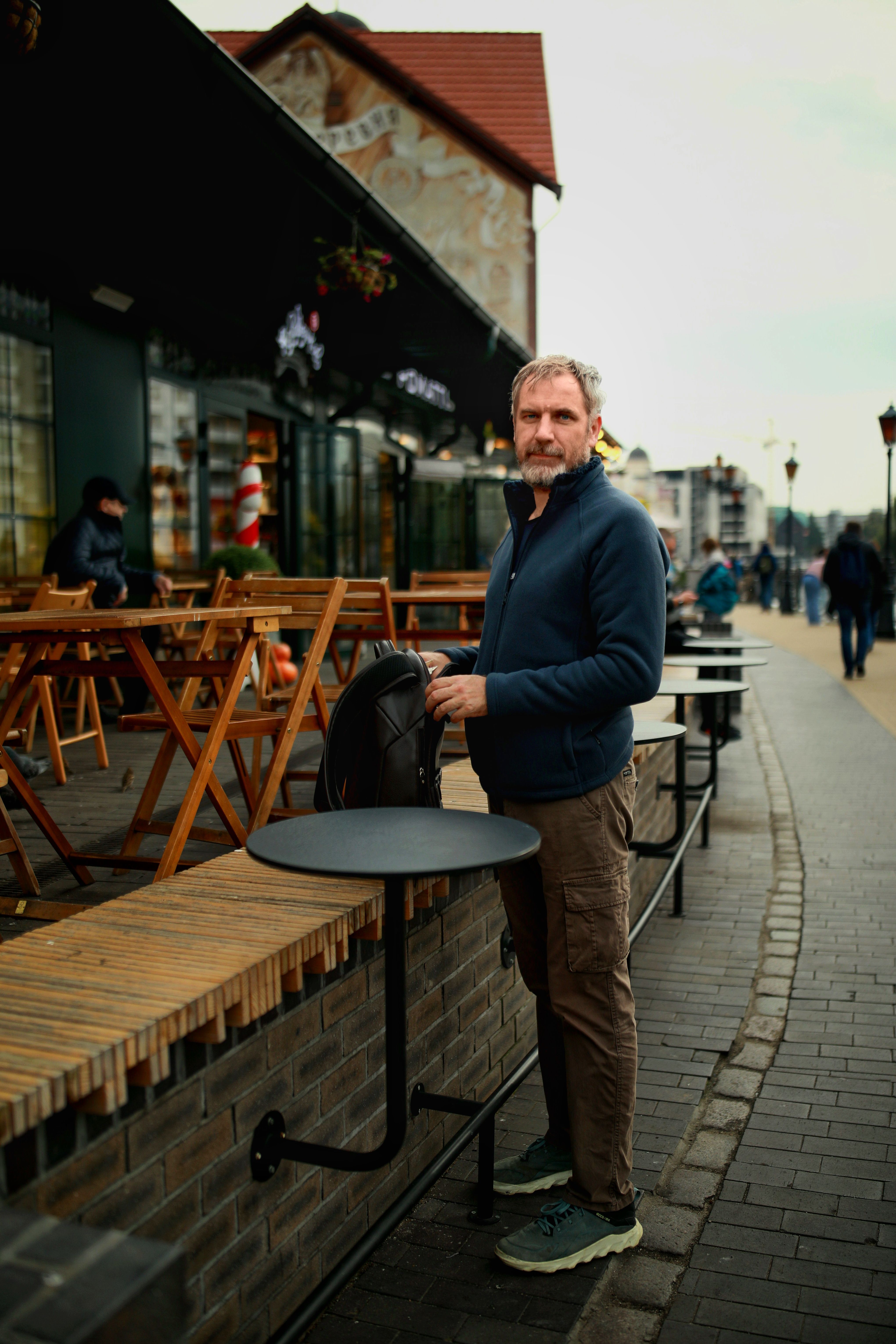 Man Standing Outside Cafe in European City Street · Free Stock Photo