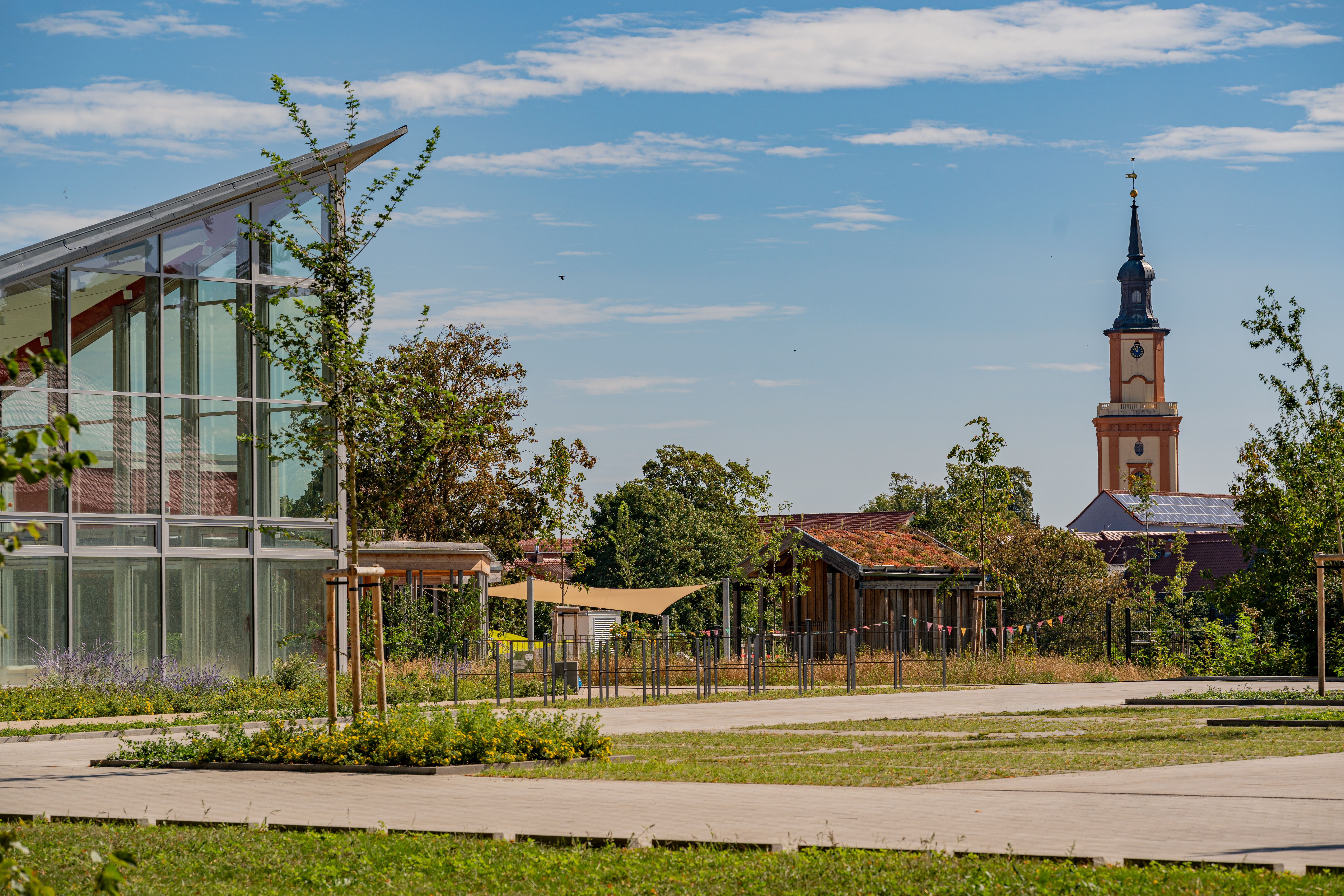 Modern Glass Building with Historic Church Tower · Free Stock Photo