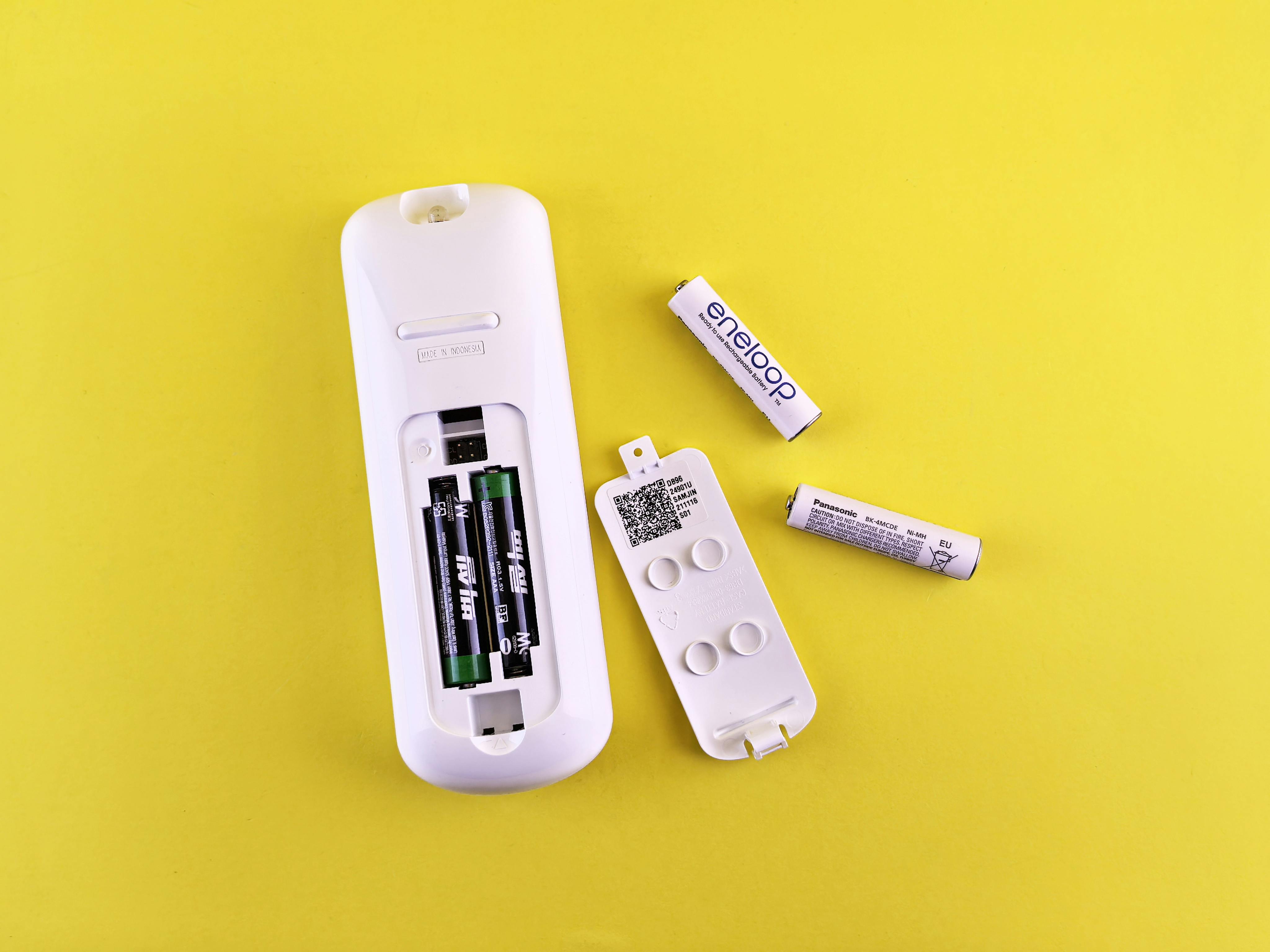 Remote Control with Batteries on Yellow Background · Free Stock Photo