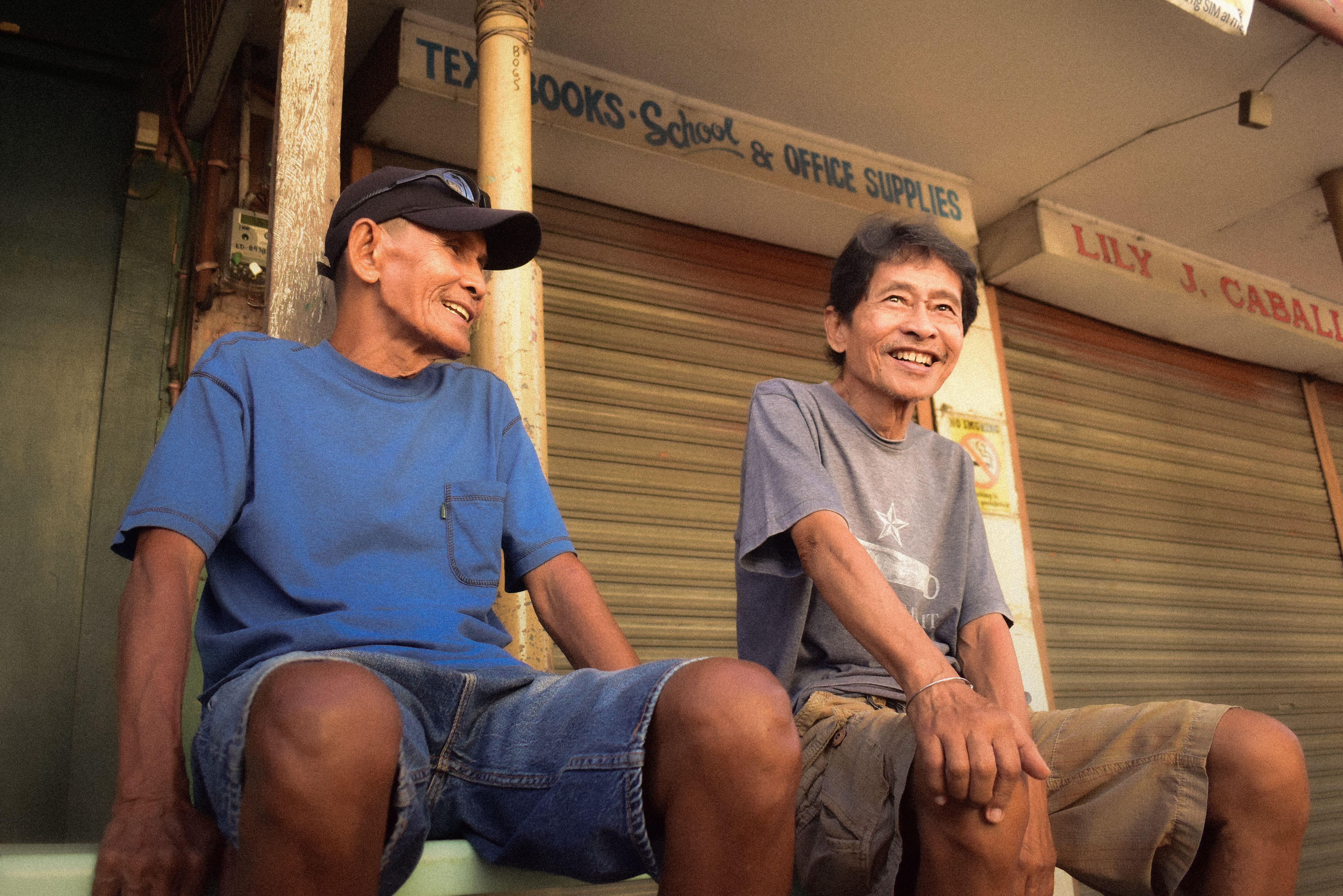 Two Men Sharing a Laugh on Dumaguete Street · Free Stock Photo