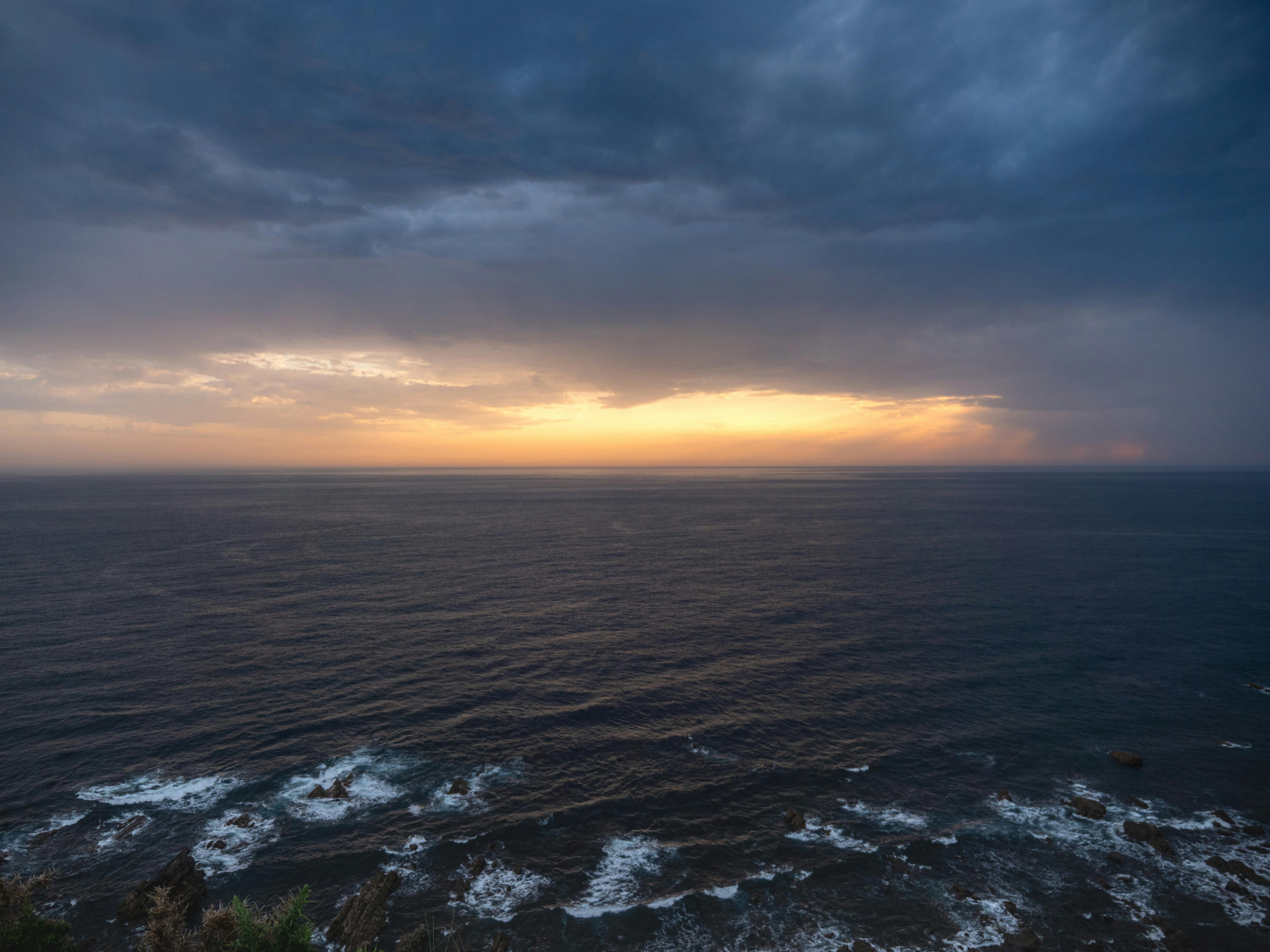 Dramatic Ocean Sunset with Overcast Sky · Free Stock Photo