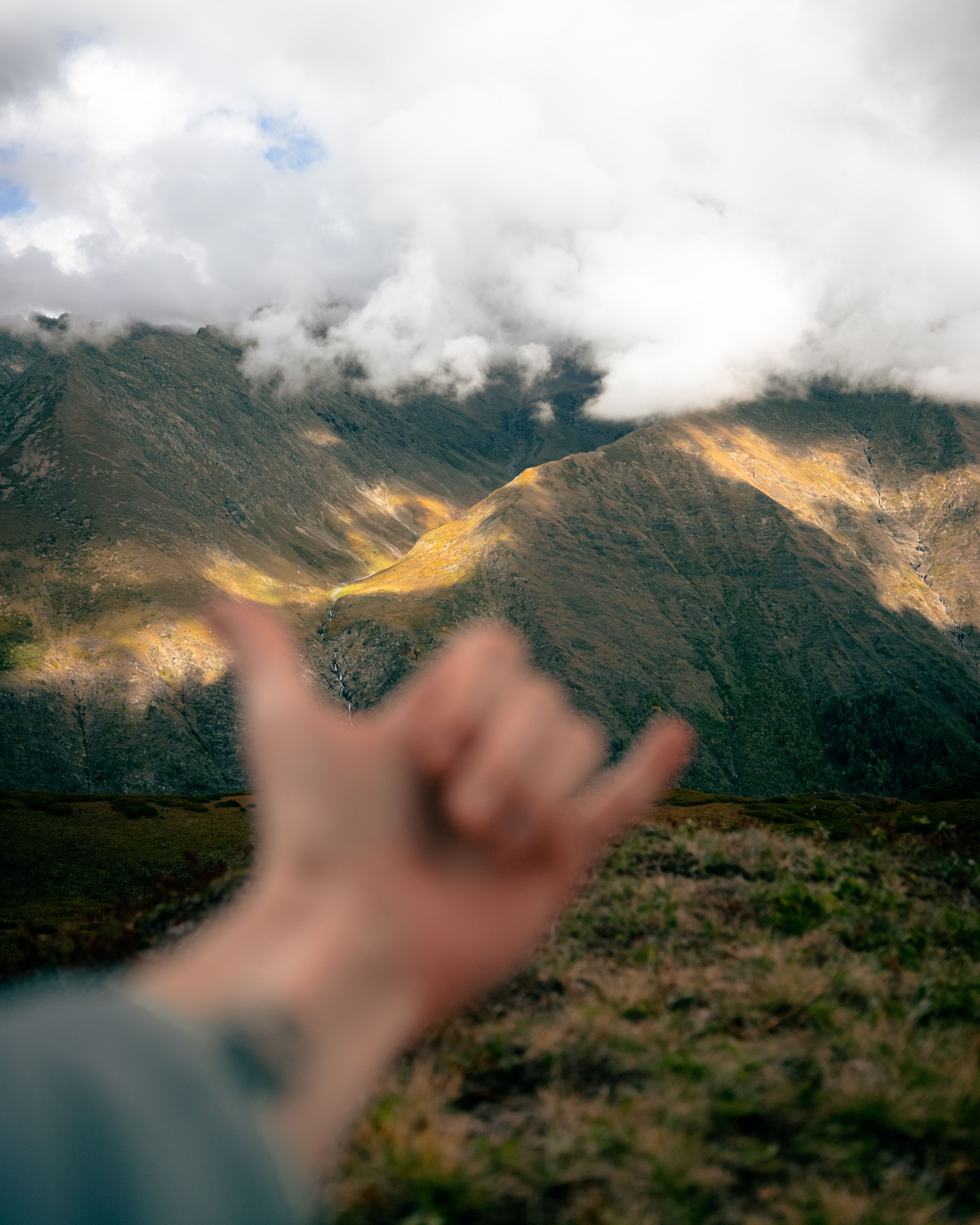 Mountain View with a Shaka Hand Gesture · Free Stock Photo