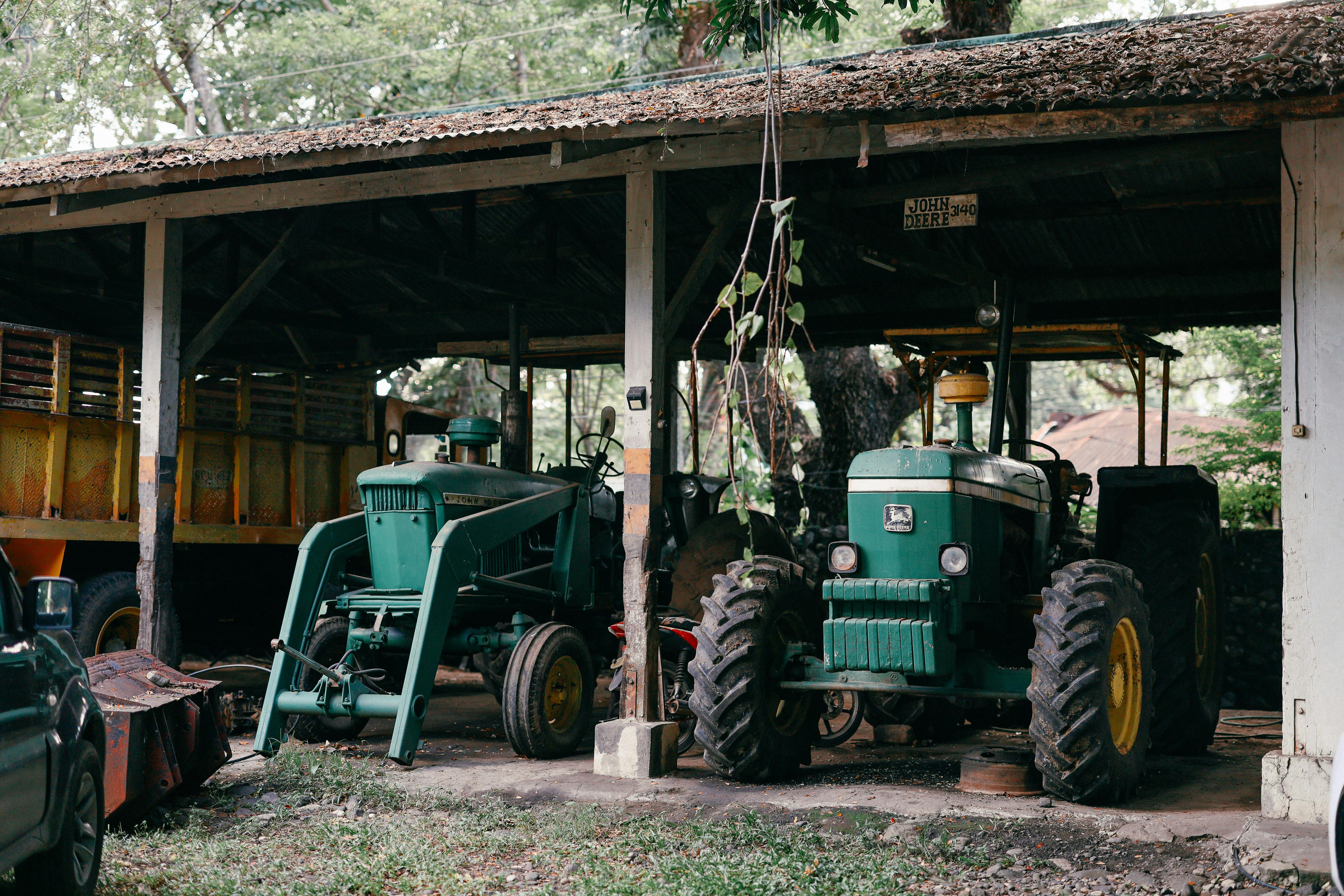 Old Tractors in Rustic Farm Shed Setting · Free Stock Photo