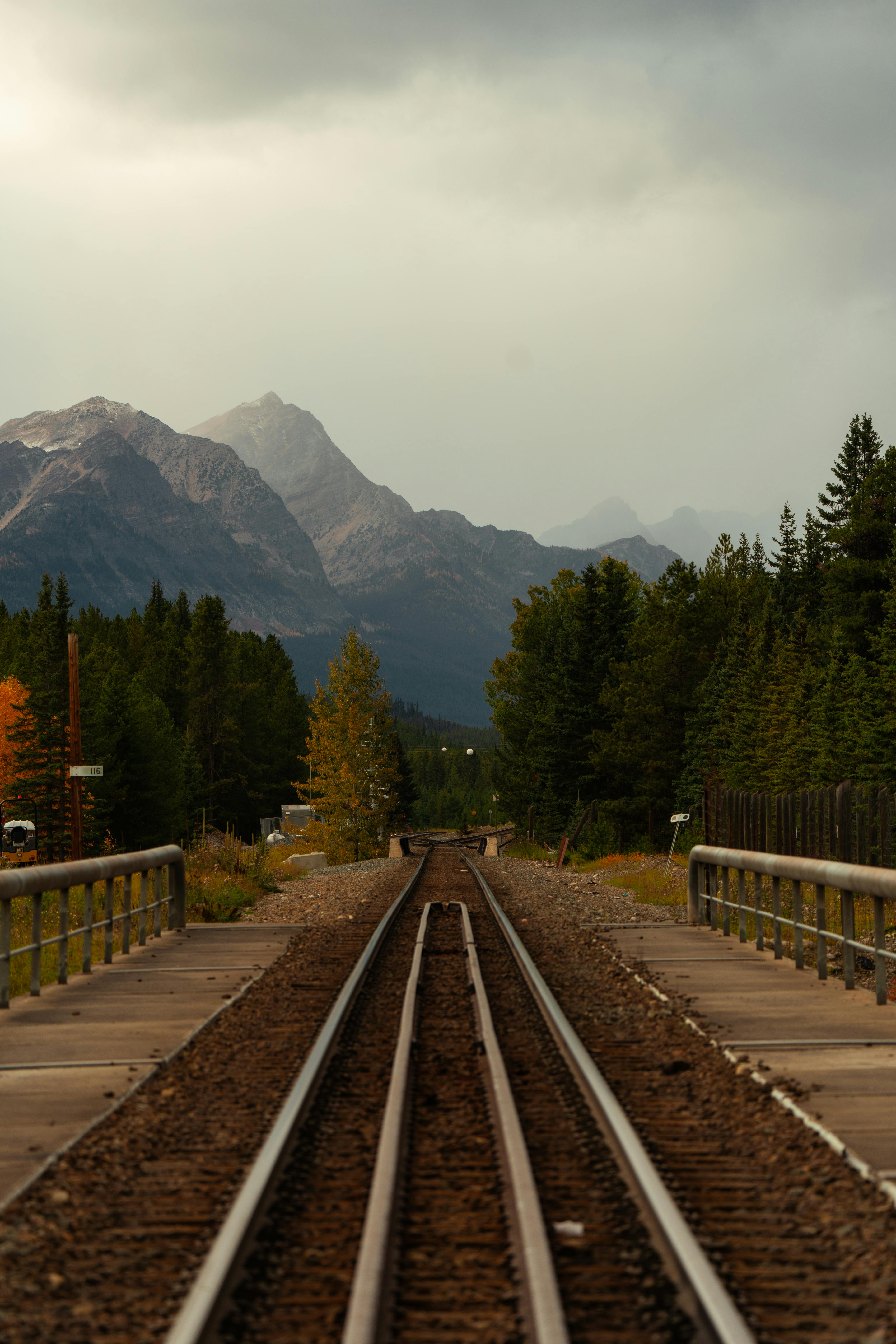 Railroad tracks leading to mountain landscape · Free Stock Photo
