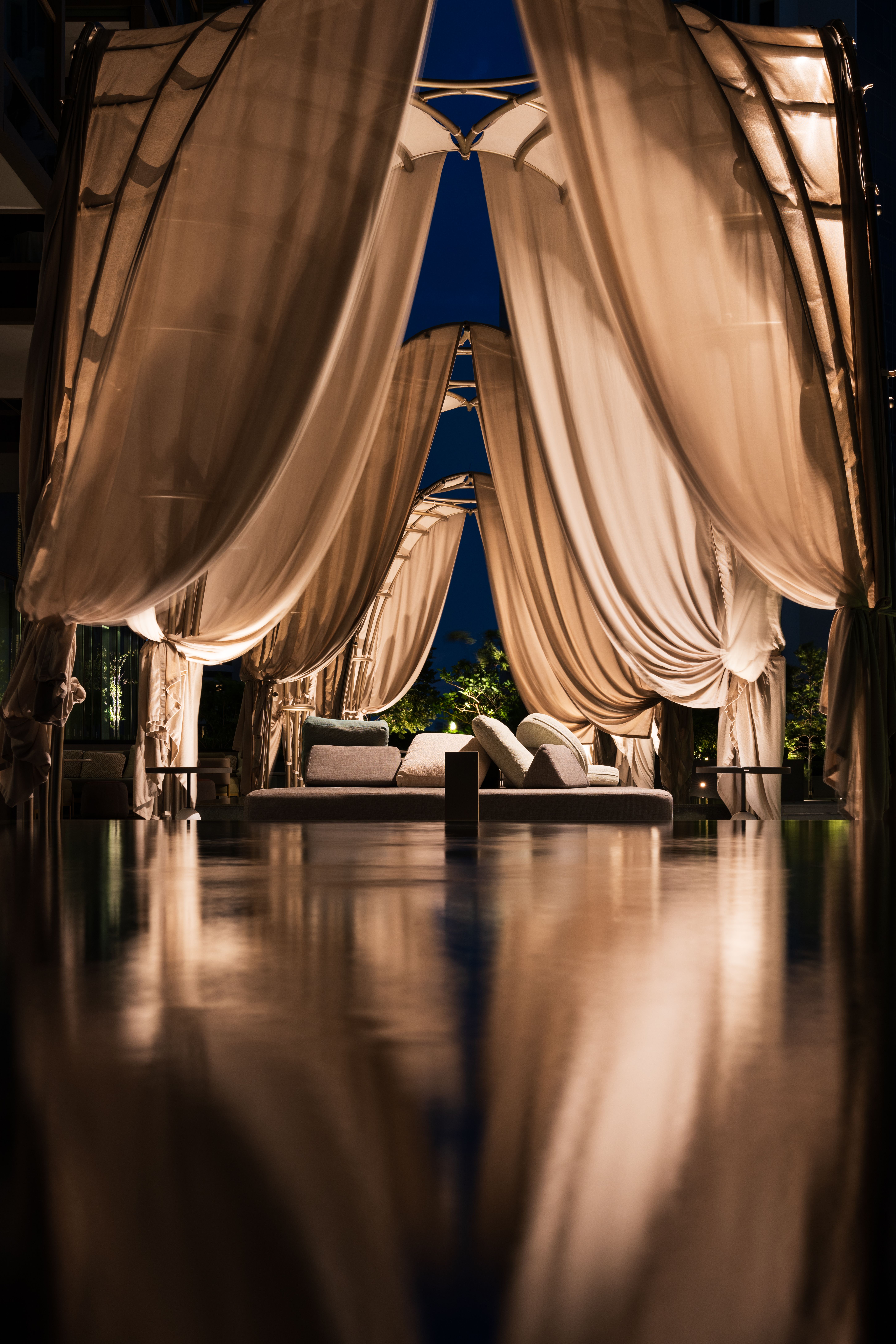 Luxurious Outdoor Cabana with Draped Curtains at Night · Free Stock Photo