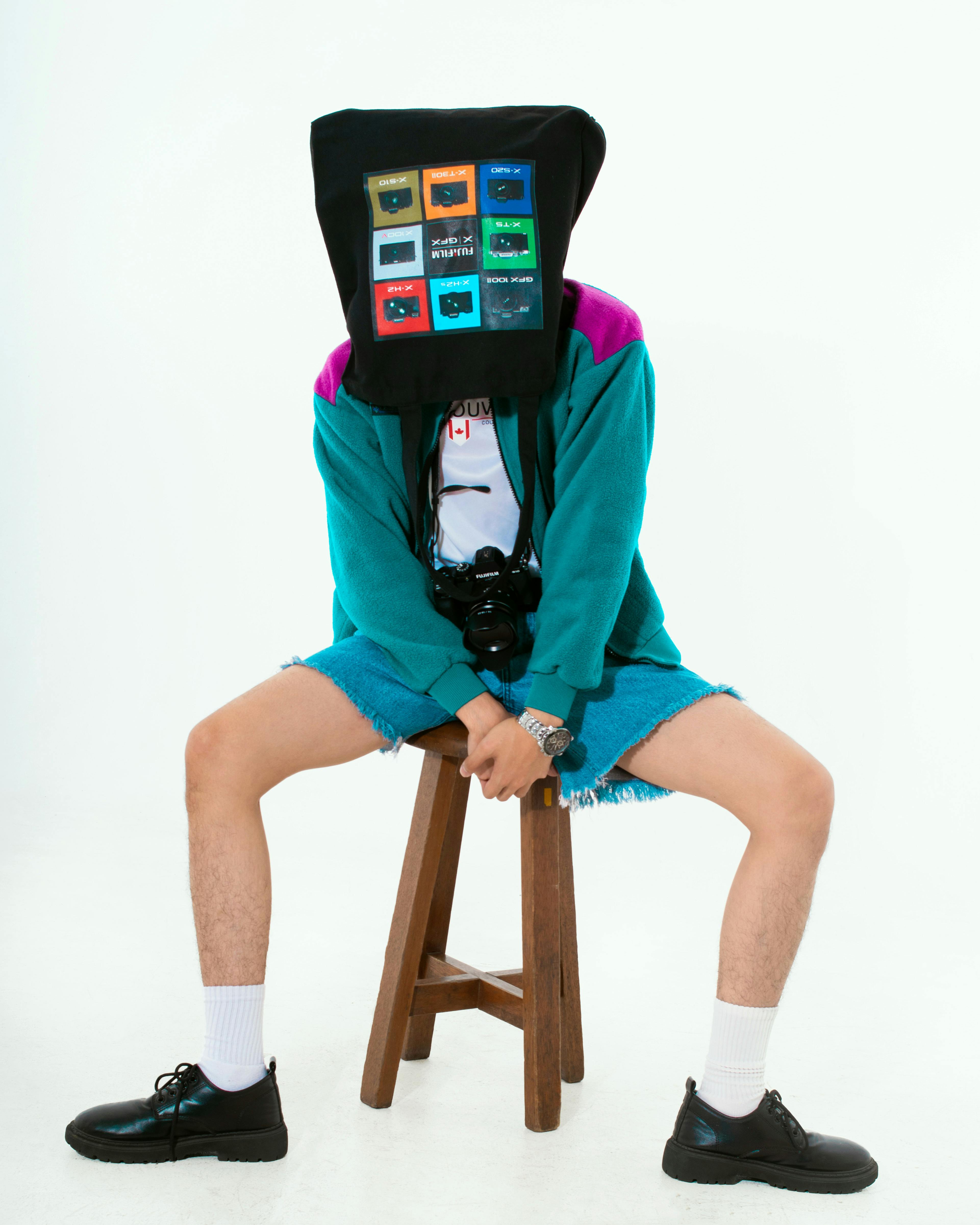 Anonymous Photographer with Concealed Identity on Stool · Free Stock Photo