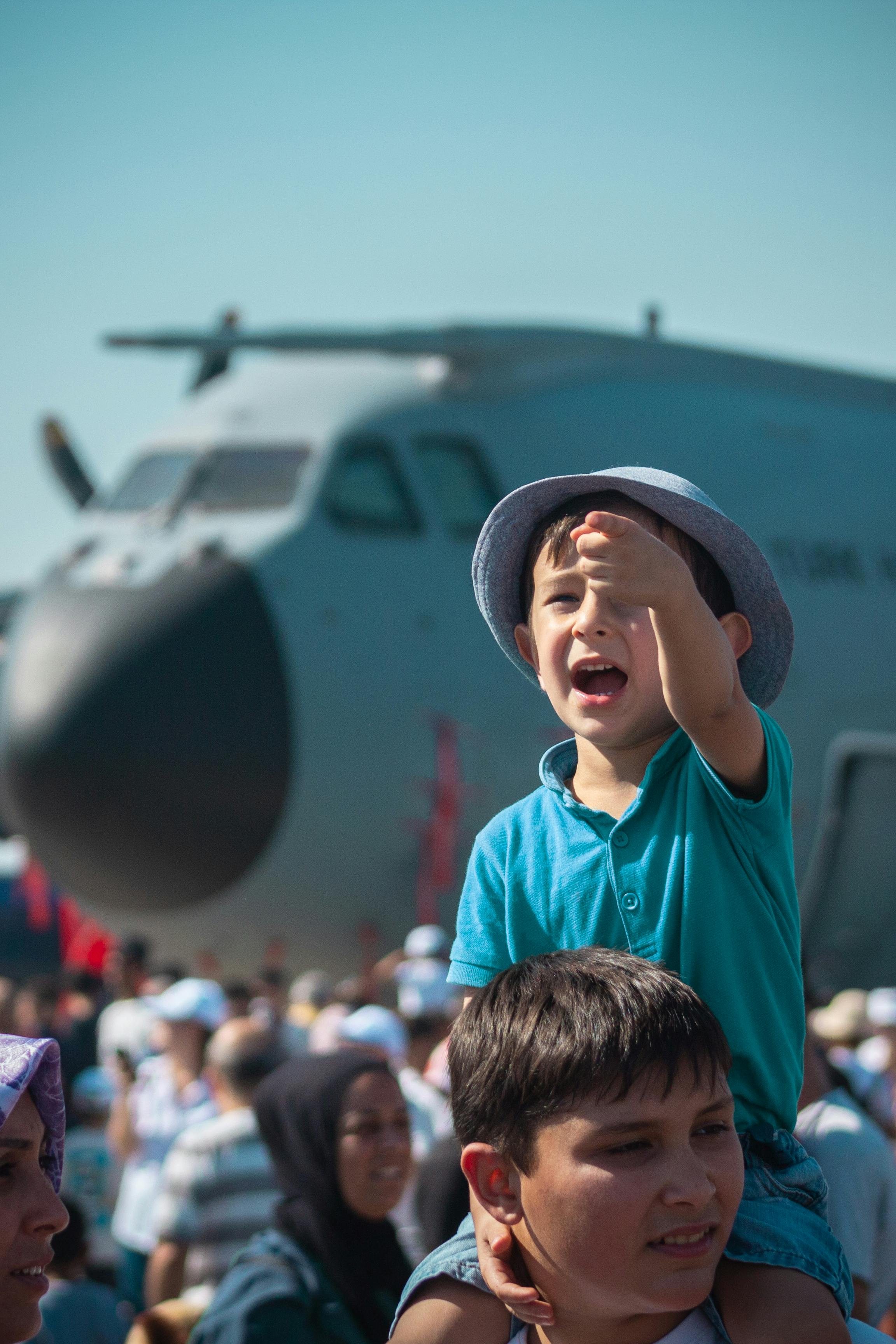 Excited Child Enjoying Aviation Show with Family · Free Stock Photo