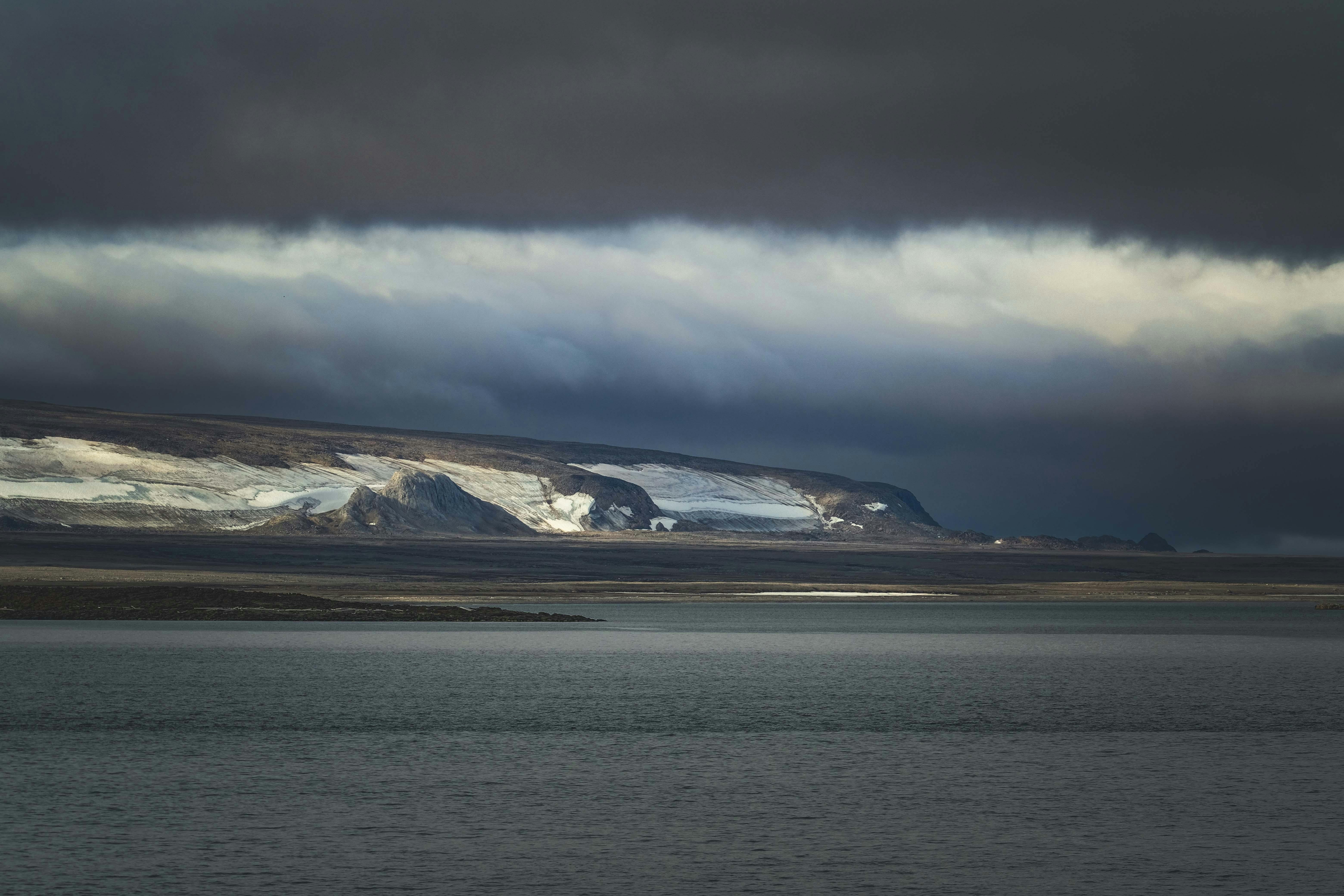 Dramatic Arctic Landscape with Glacier and Dark Clouds · Free Stock Photo