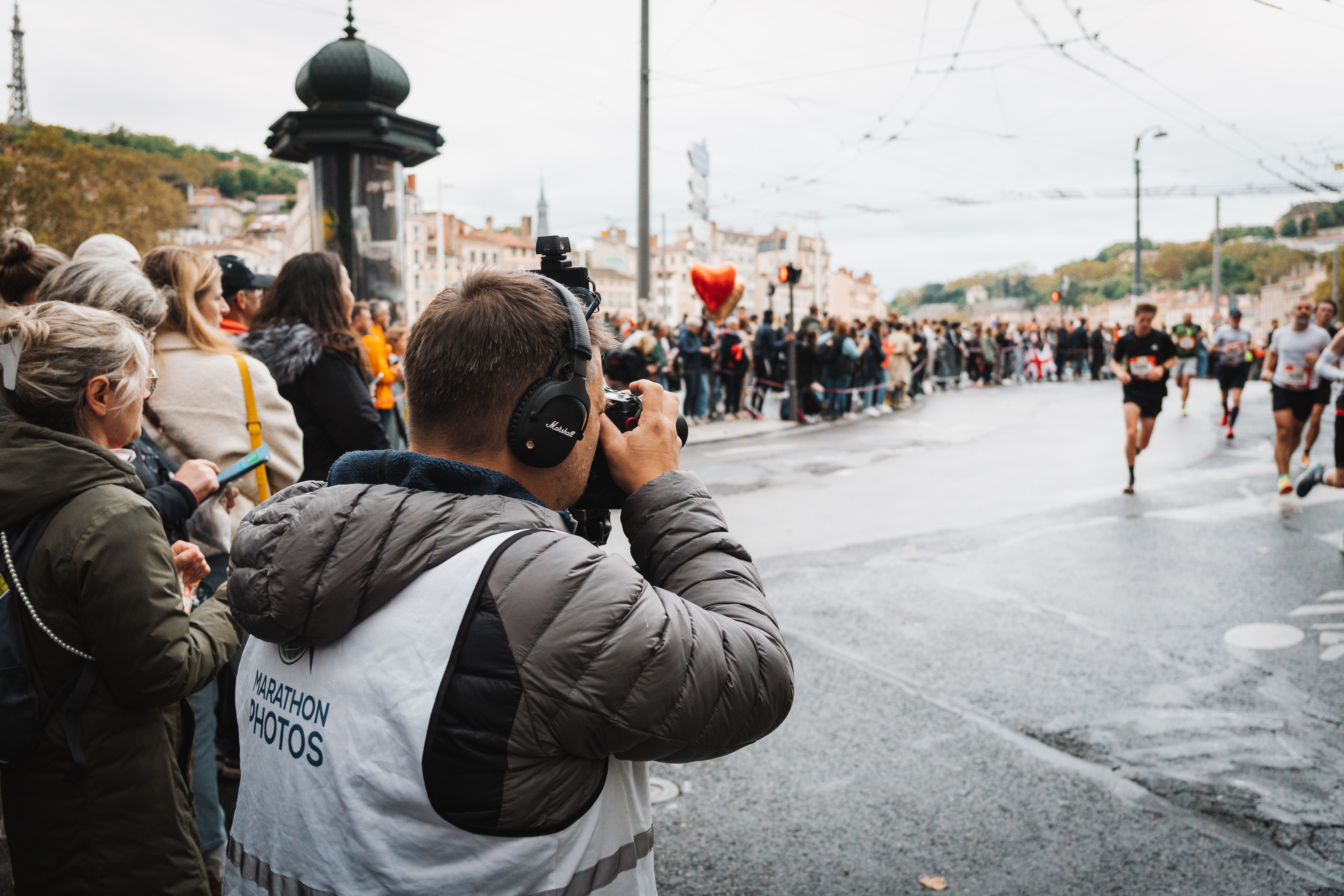 Photographer capturing marathon runners outdoors · Free Stock Photo