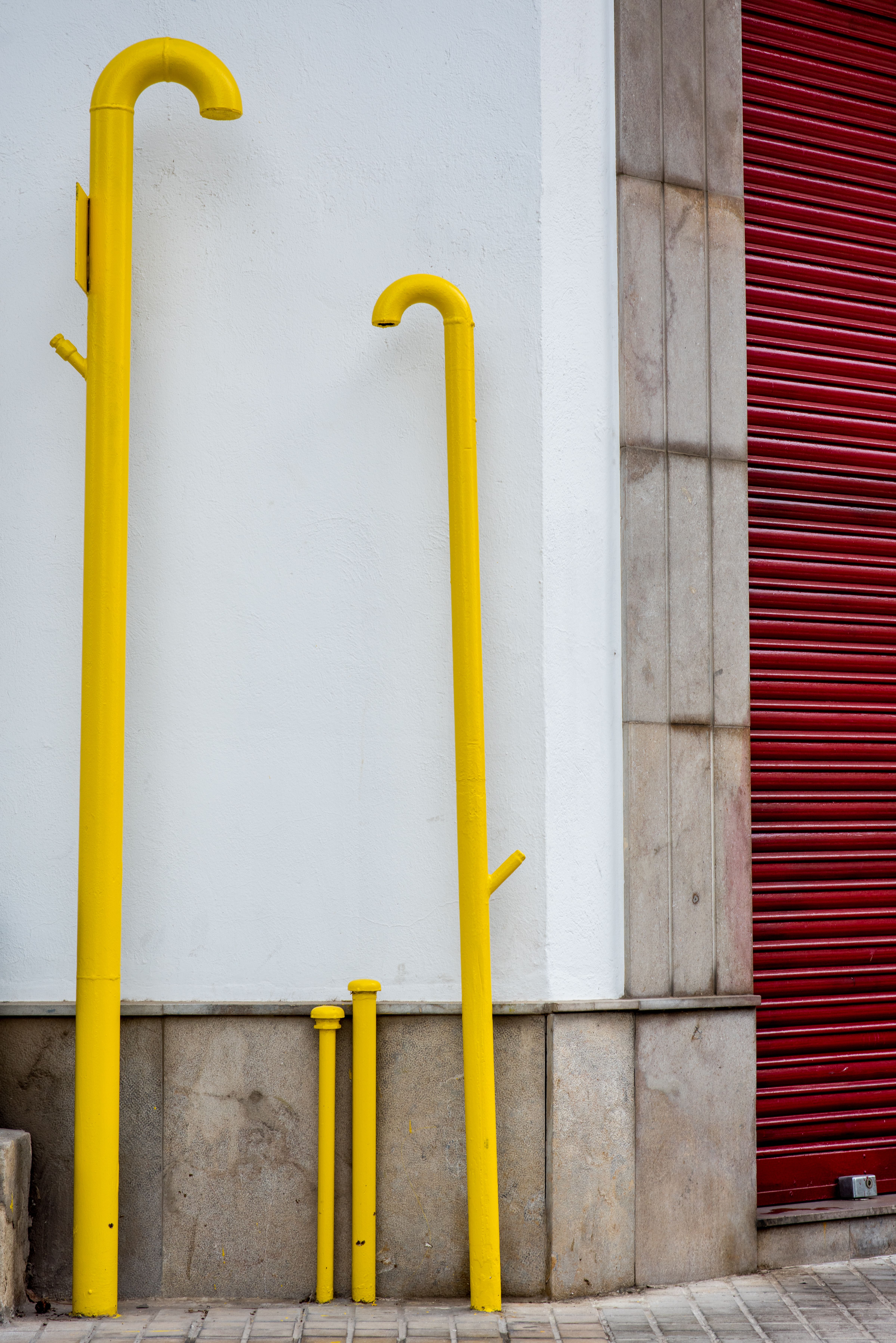 Vibrant Yellow Pipes Against Urban Wall · Free Stock Photo