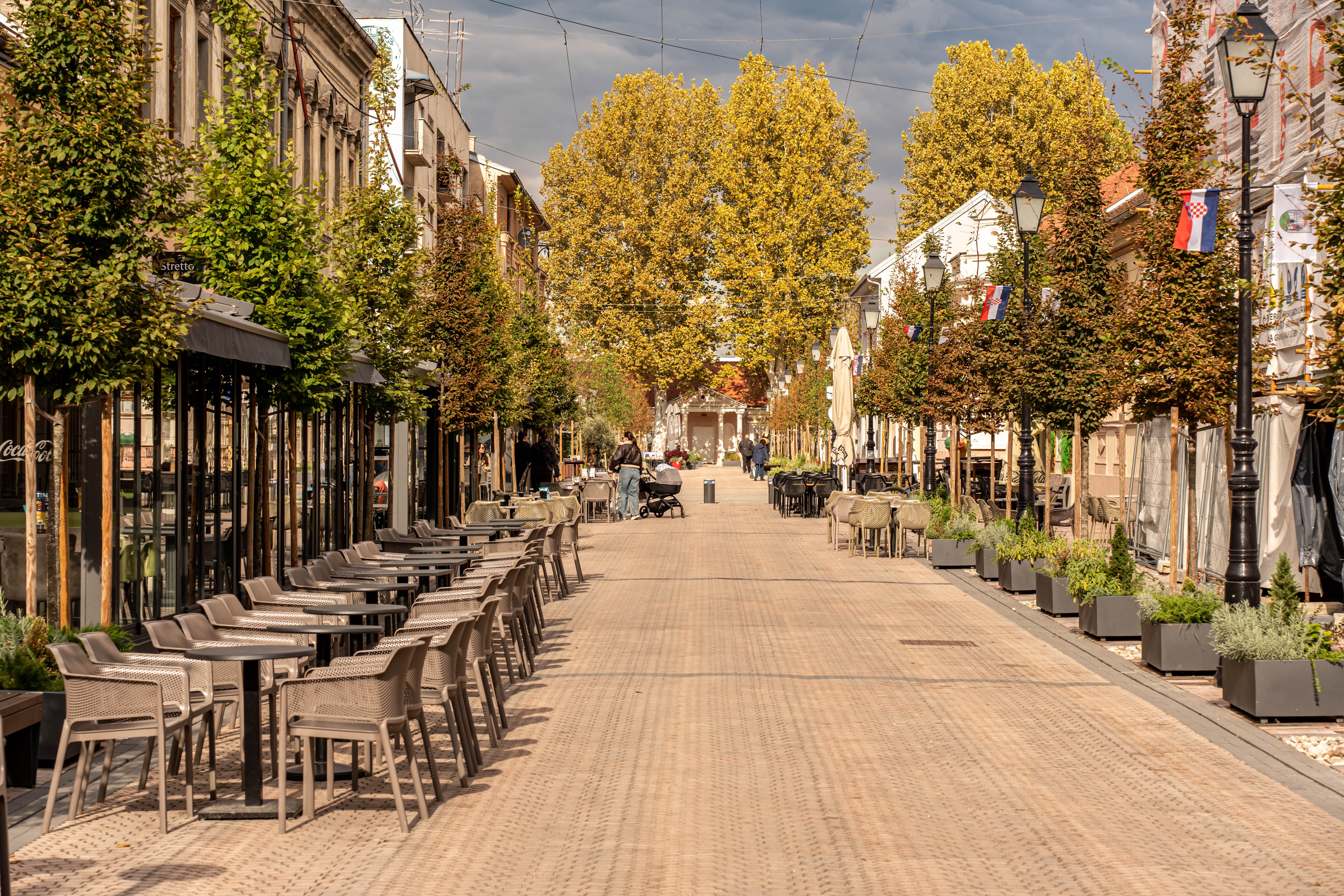 Charming European Street with Outdoor Cafes in Autumn · Free Stock Photo