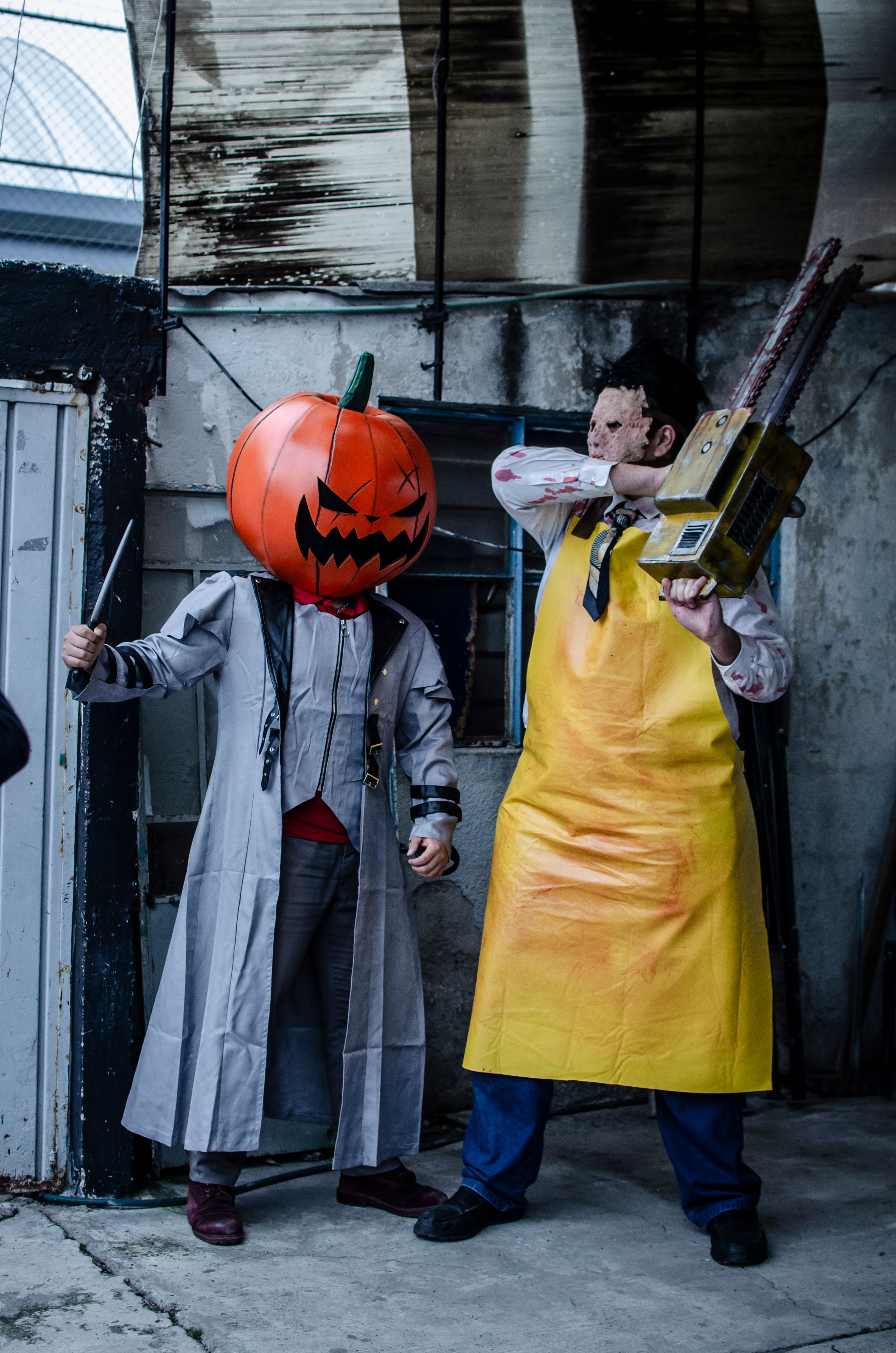 Spooky Halloween Cosplay with Chainsaw and Pumpkin · Free Stock Photo